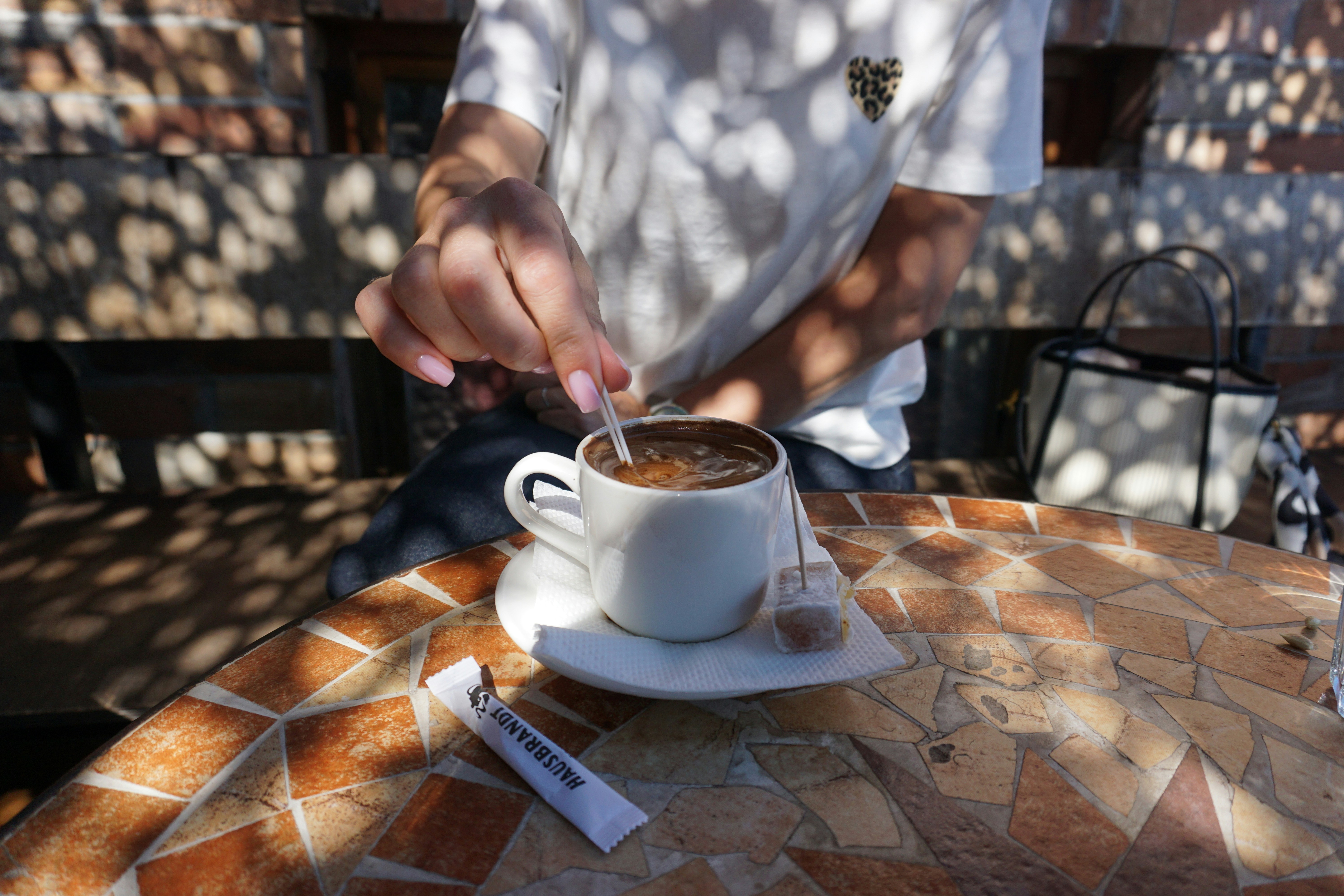 Sunlit Café Moment: Frothy Coffee and a Quiet Sip