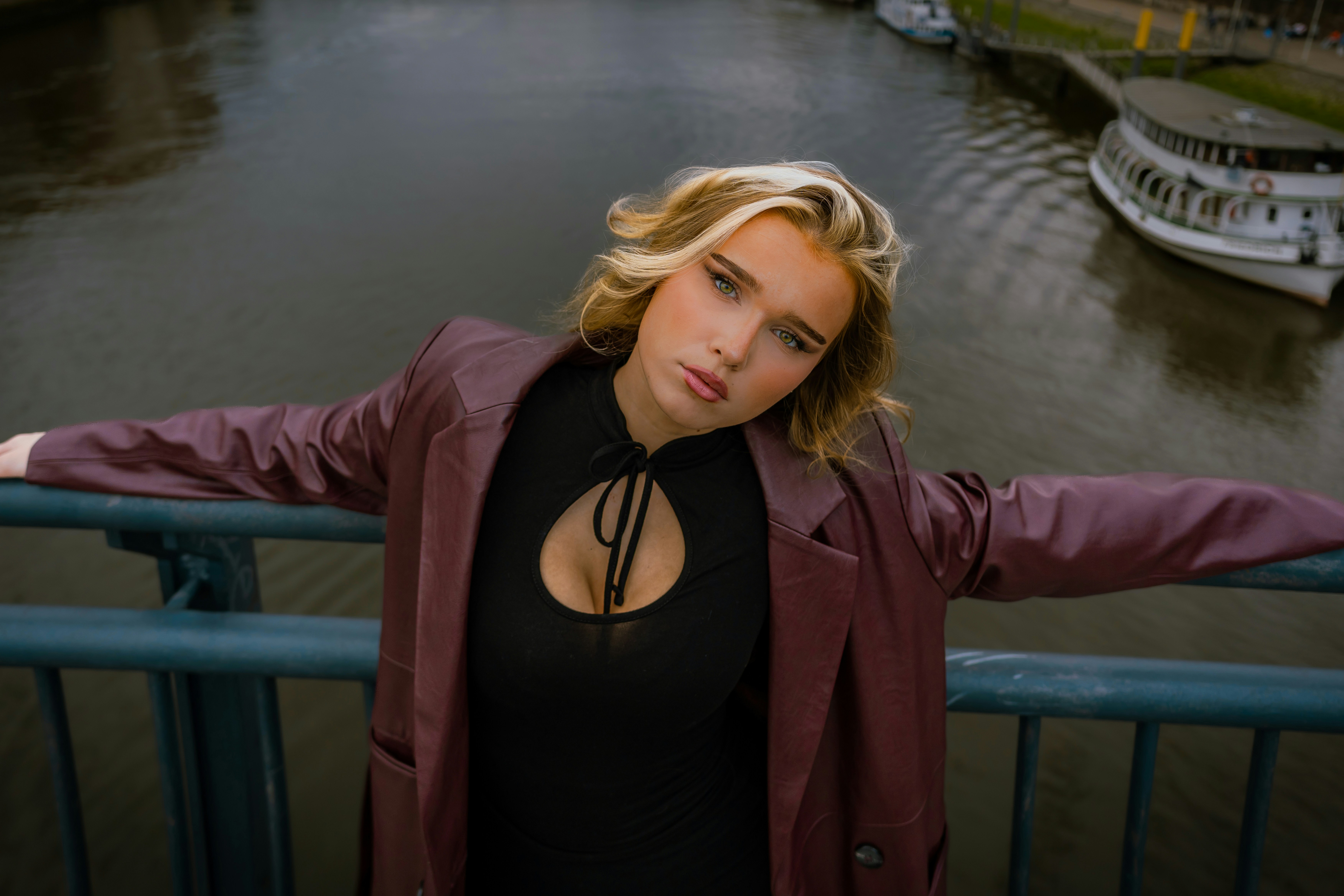 Crossed arms, city river, and a confident gaze