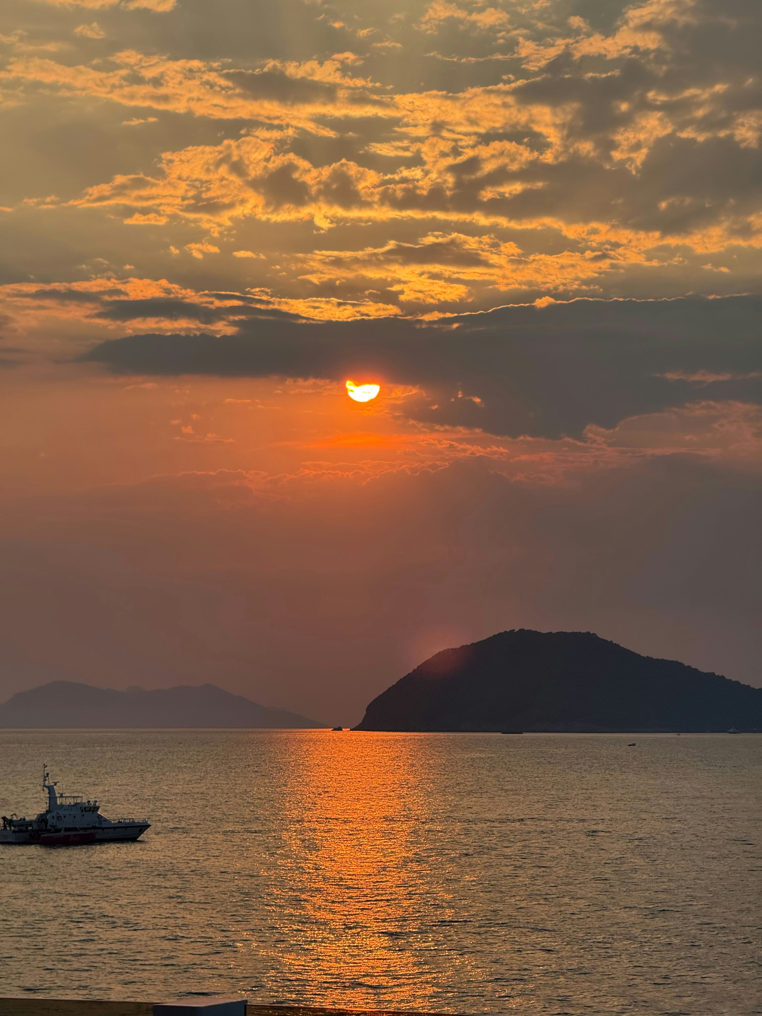 Sunset over a Quiet Gulf: Island Silhouette and a Working Boat