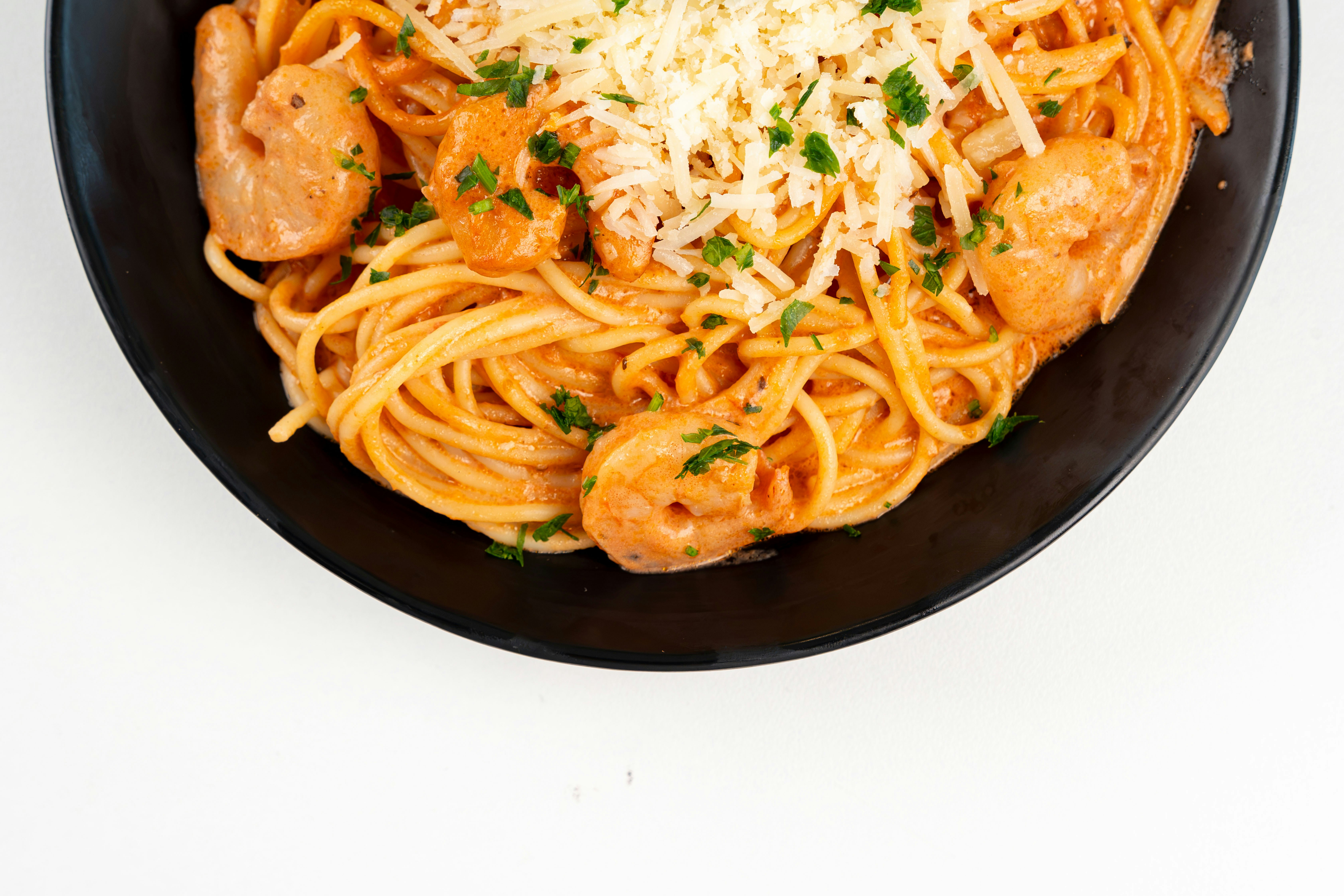 Top-Down Pan of Creamy Sausage Pepper Pasta in a Black Bowl