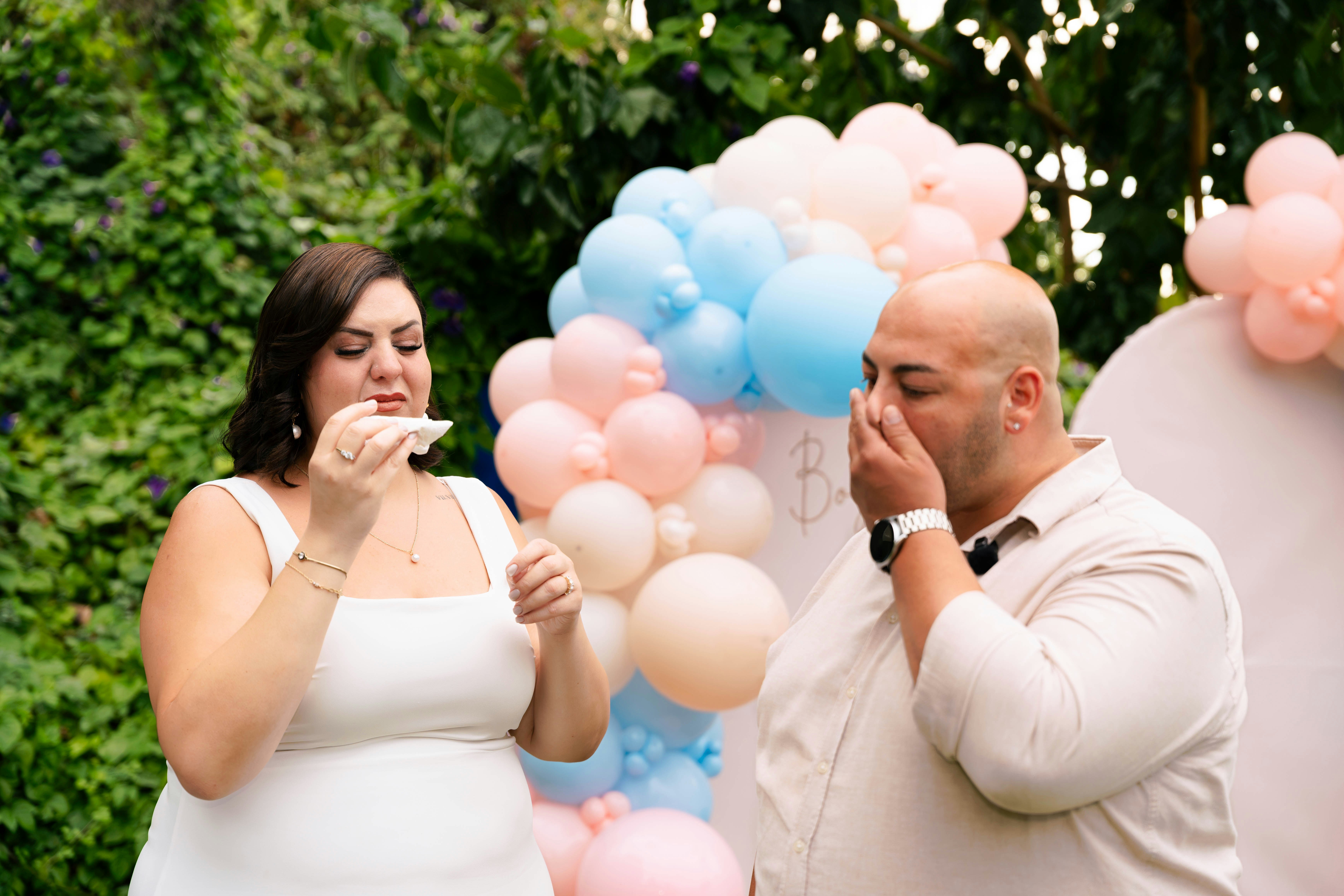 Sweet Ritual: A Couple Smiles Through a Sweet Moment at a Balloon-Decorated Celebration