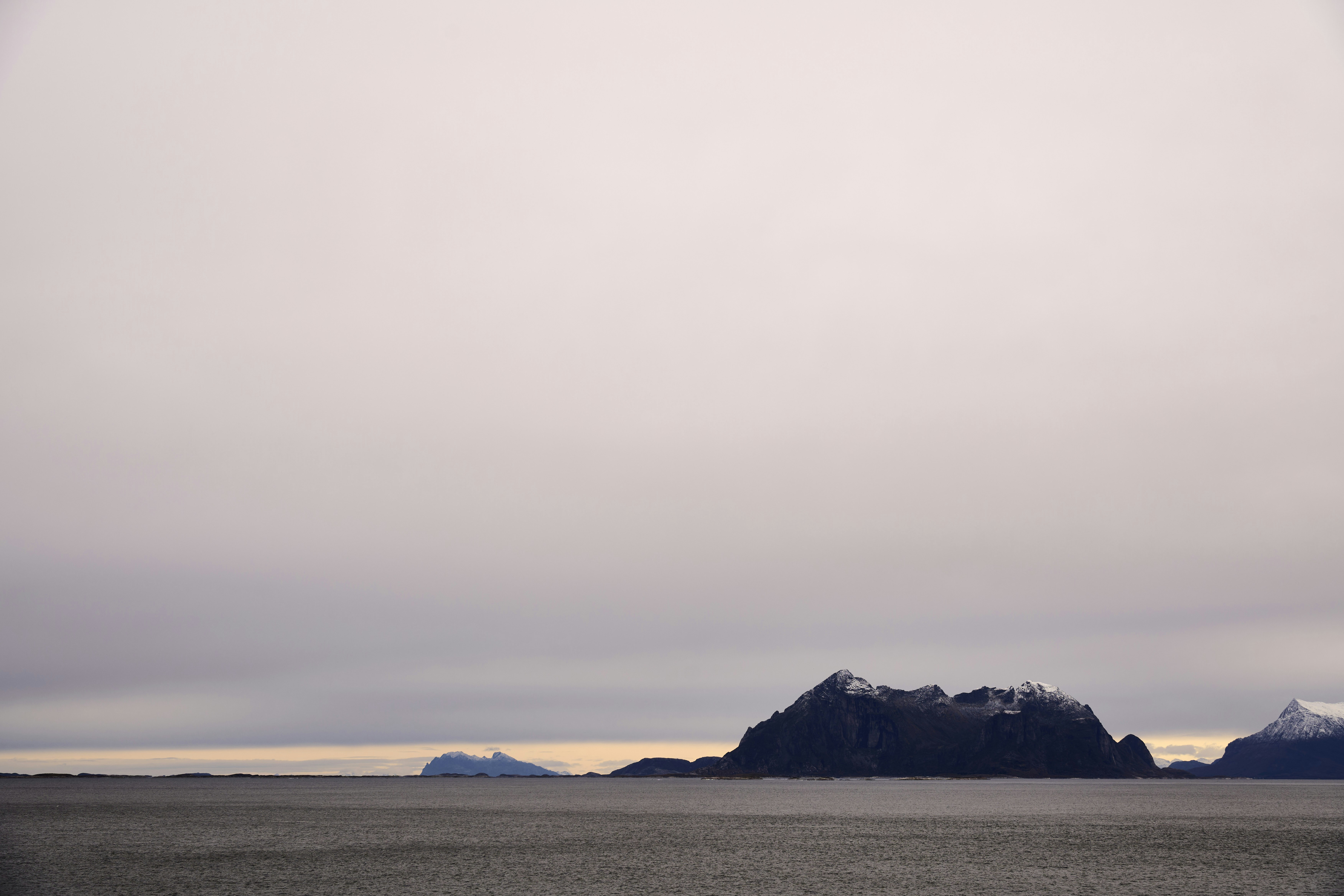Distant Isles at Dusk: Calm Sea Under Expansive Sky