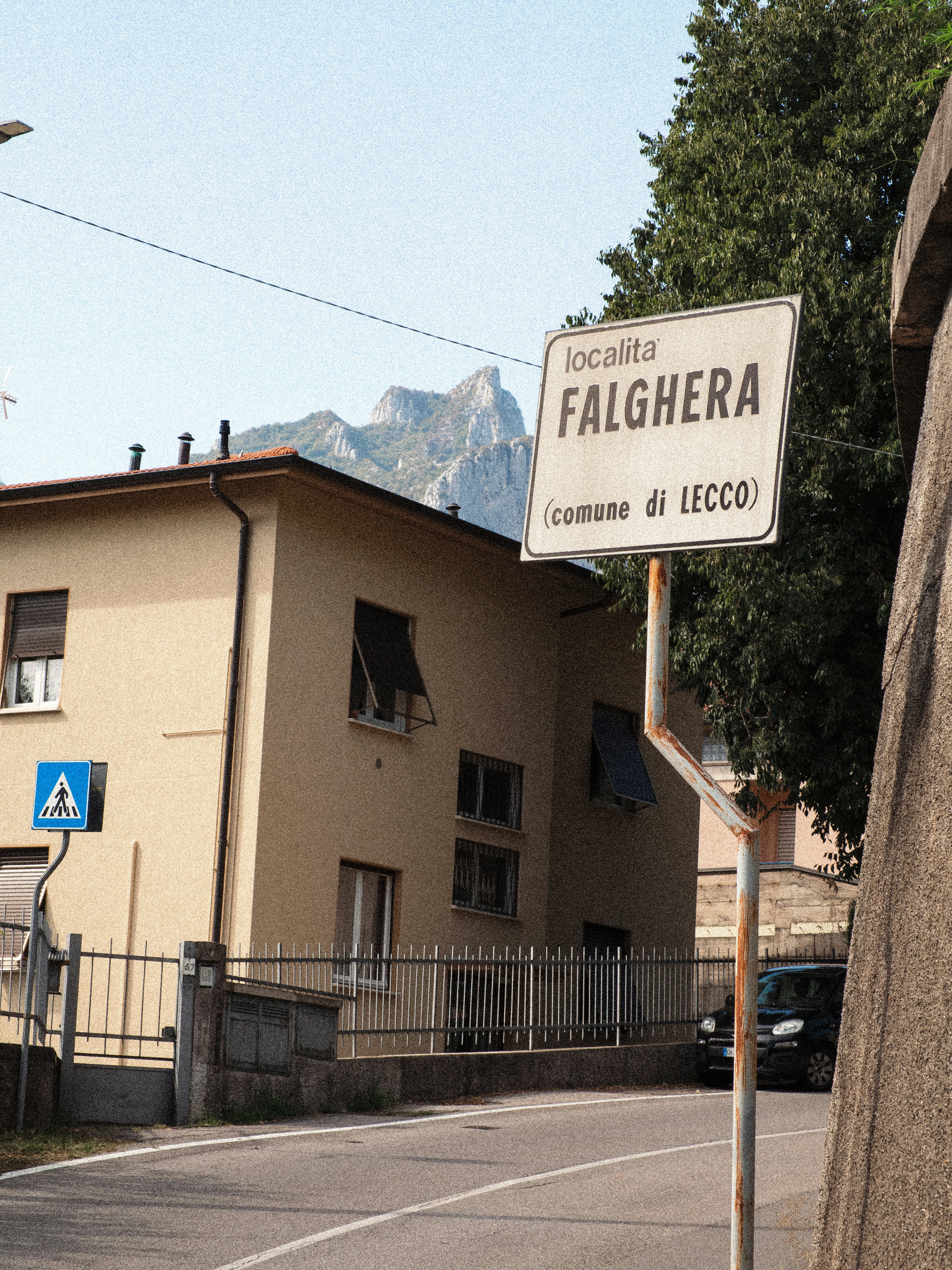 Signpost in a quiet Italian Street with Mountain Backdrop