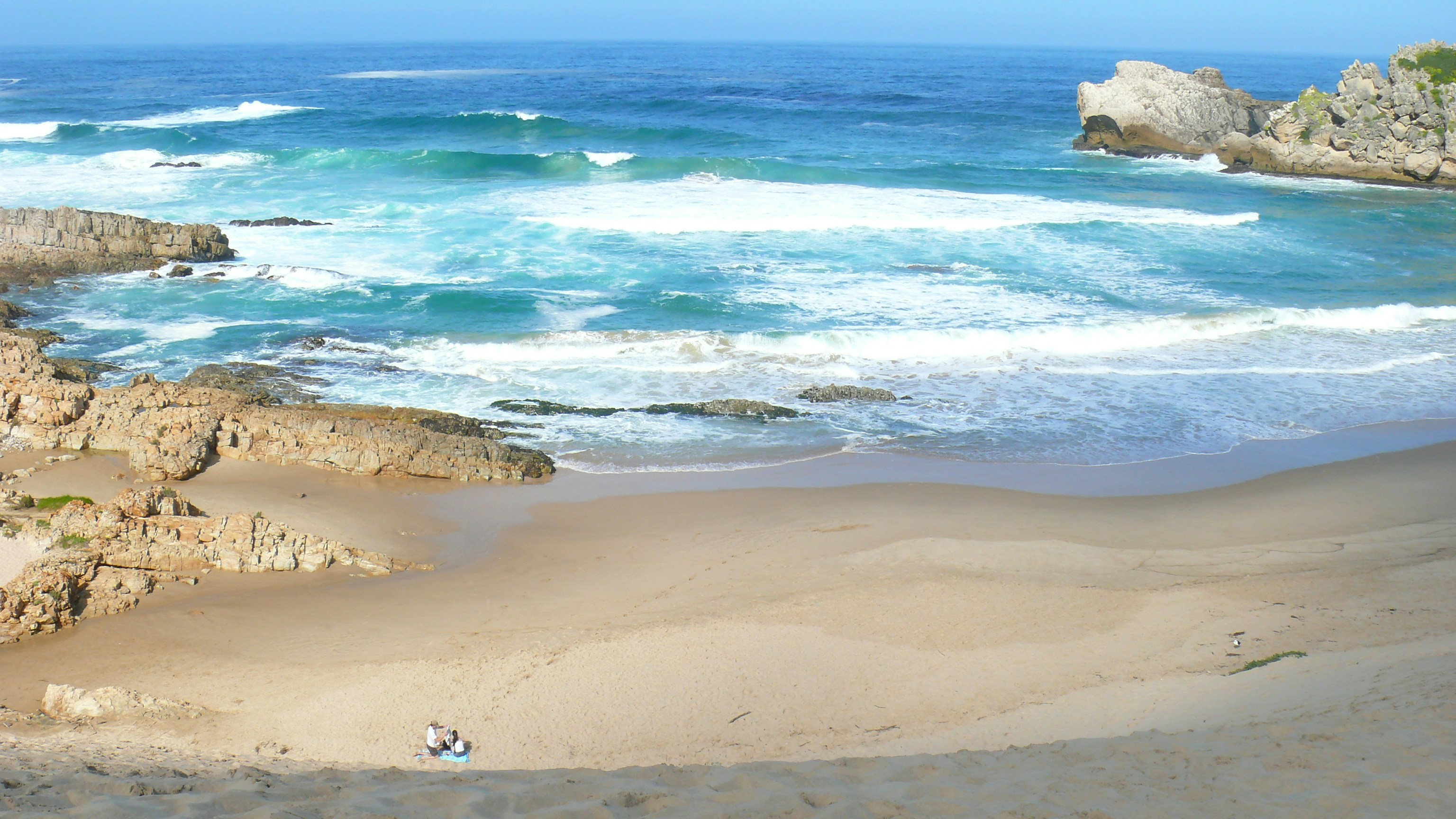 Quiet Shoreline: Sunlit Beach Meets Turquoise Crest