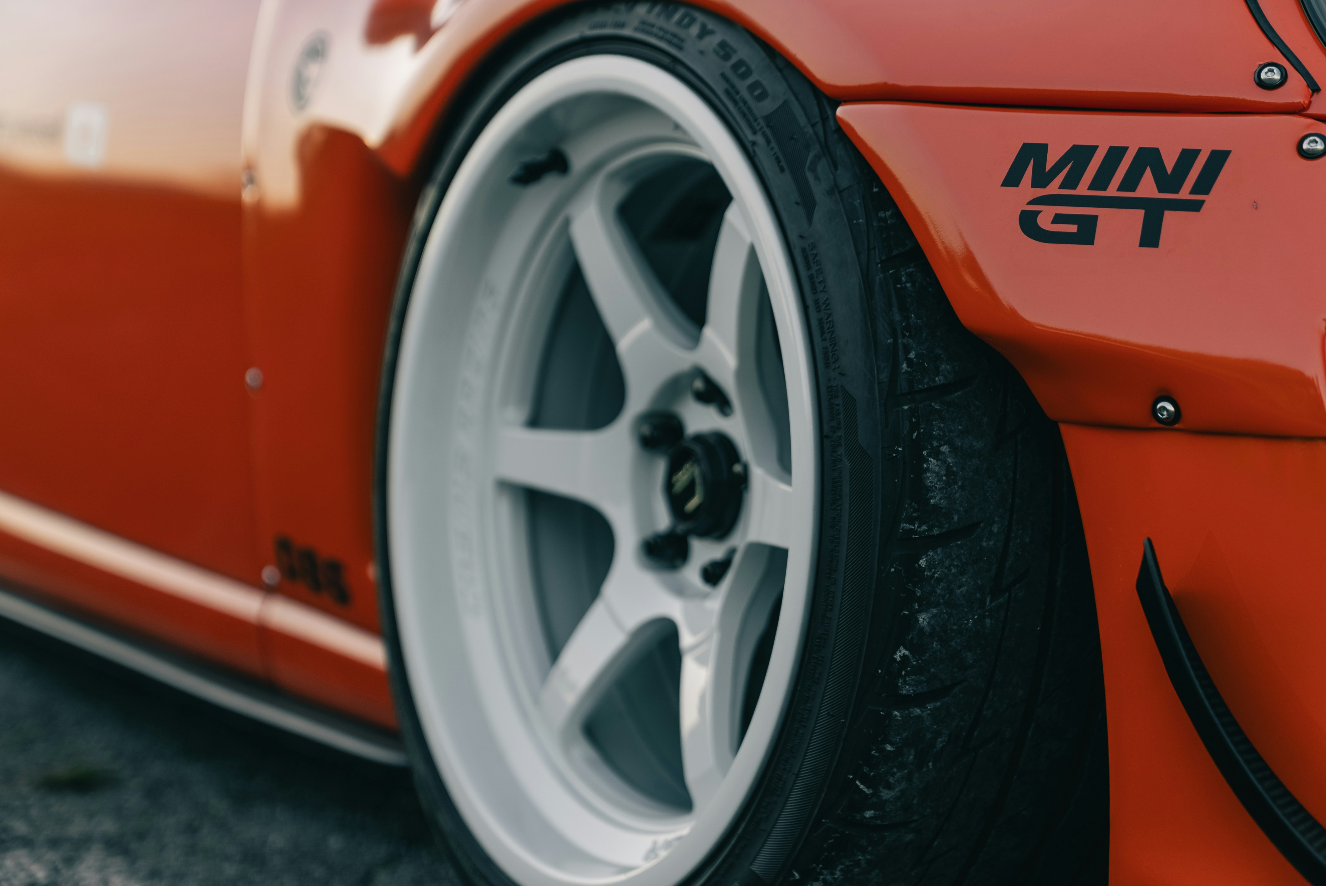 White Spoked Wheel and Red Bodywork: A Close-Up of a MINI GT