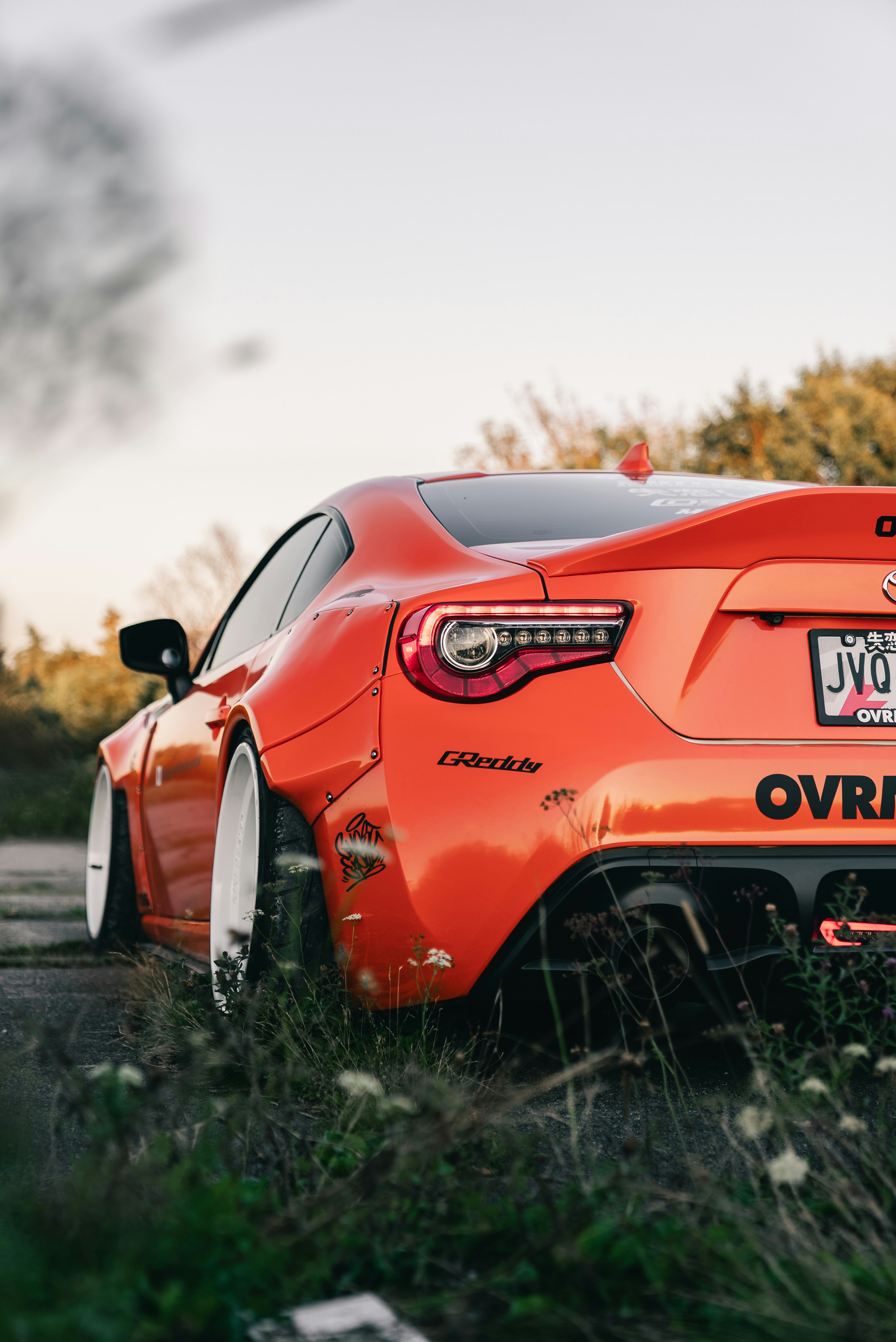 Orange Drift: Rear Quarter View of a lowered Nissan with Bold Graphics