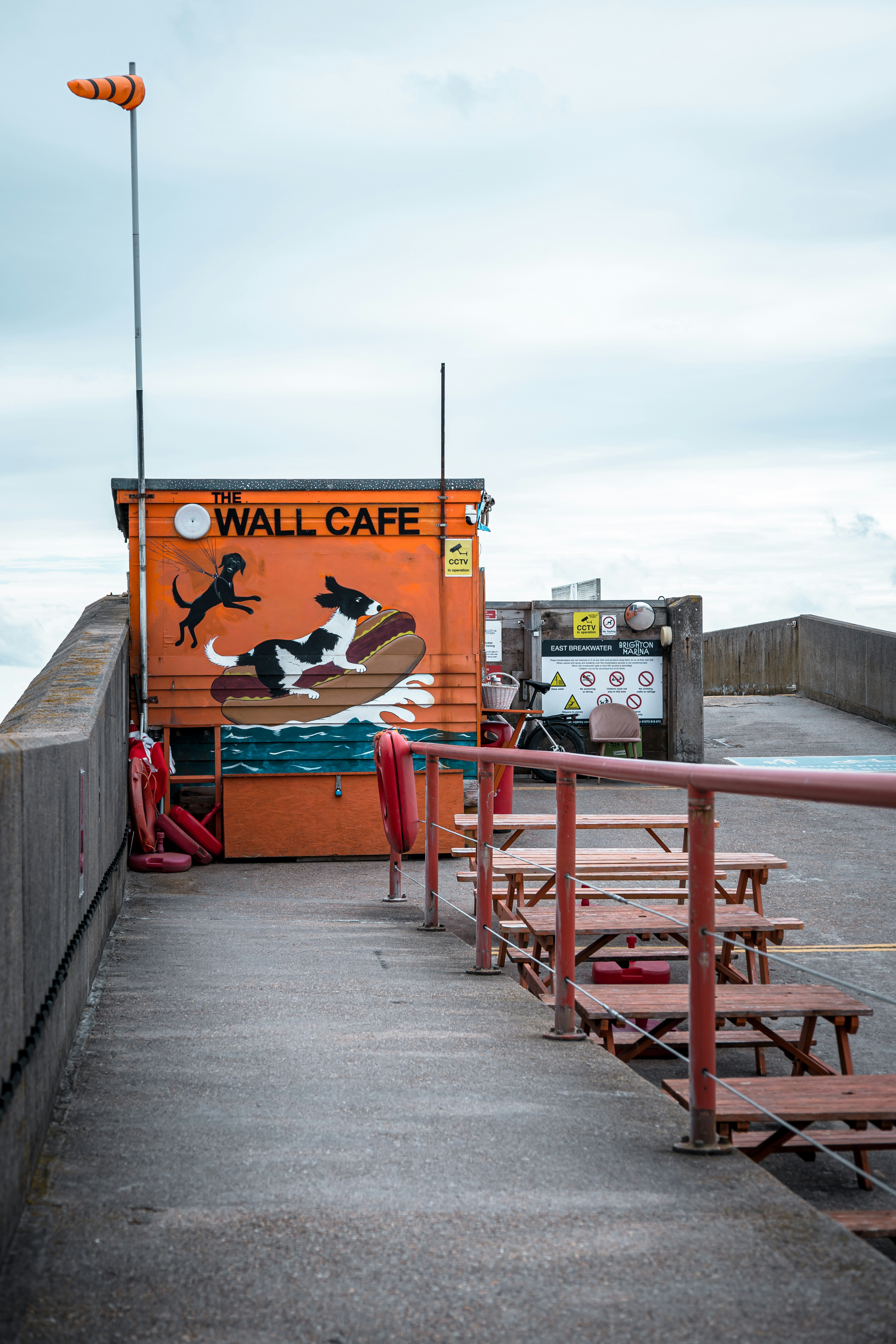 Orange Shack by the Pier: Wall Café Illustration on a Wind-Swept Concourse