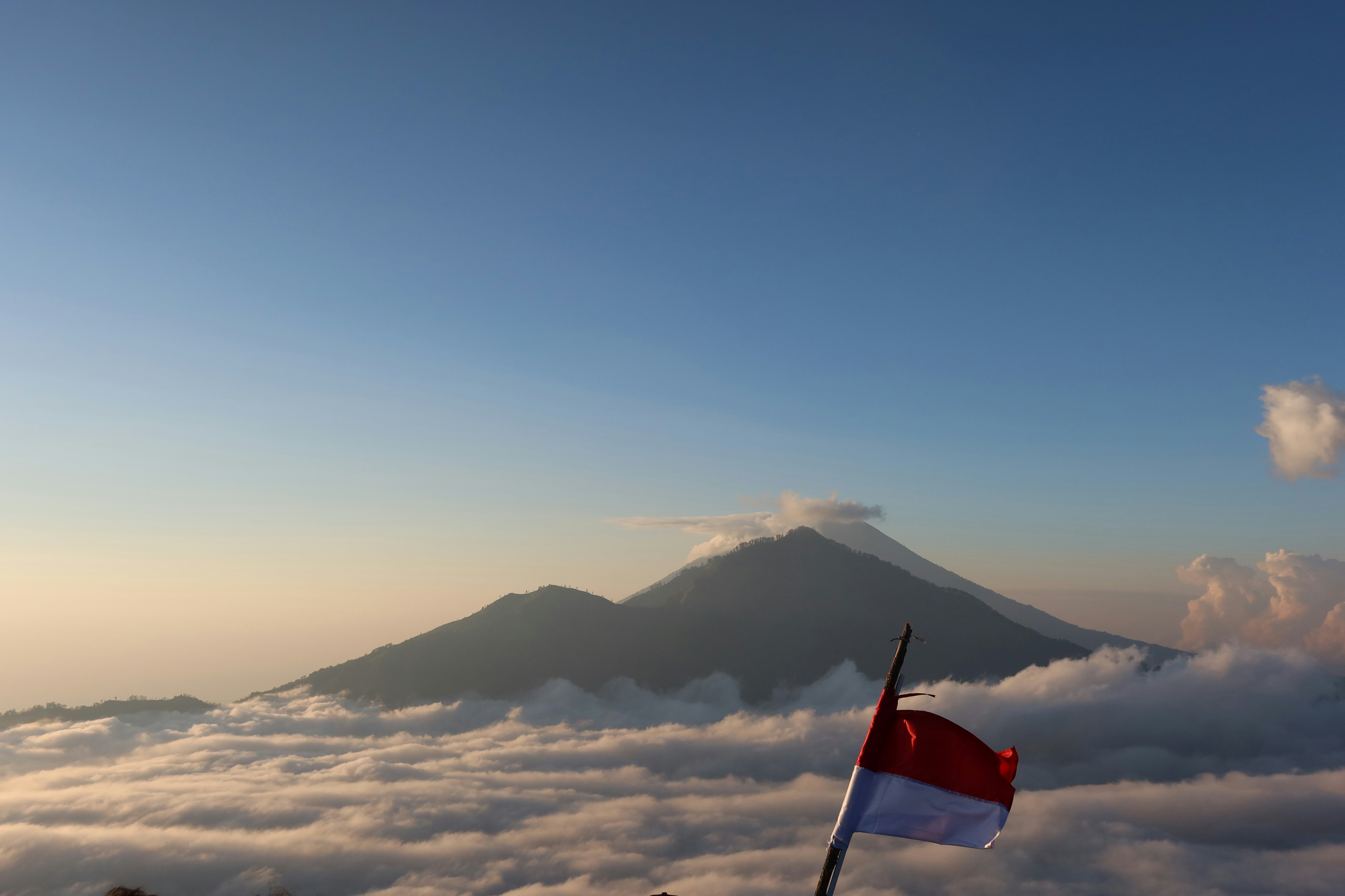 Smoke-kissed Summit: A Lone Flag Framing a Volcanic Silence