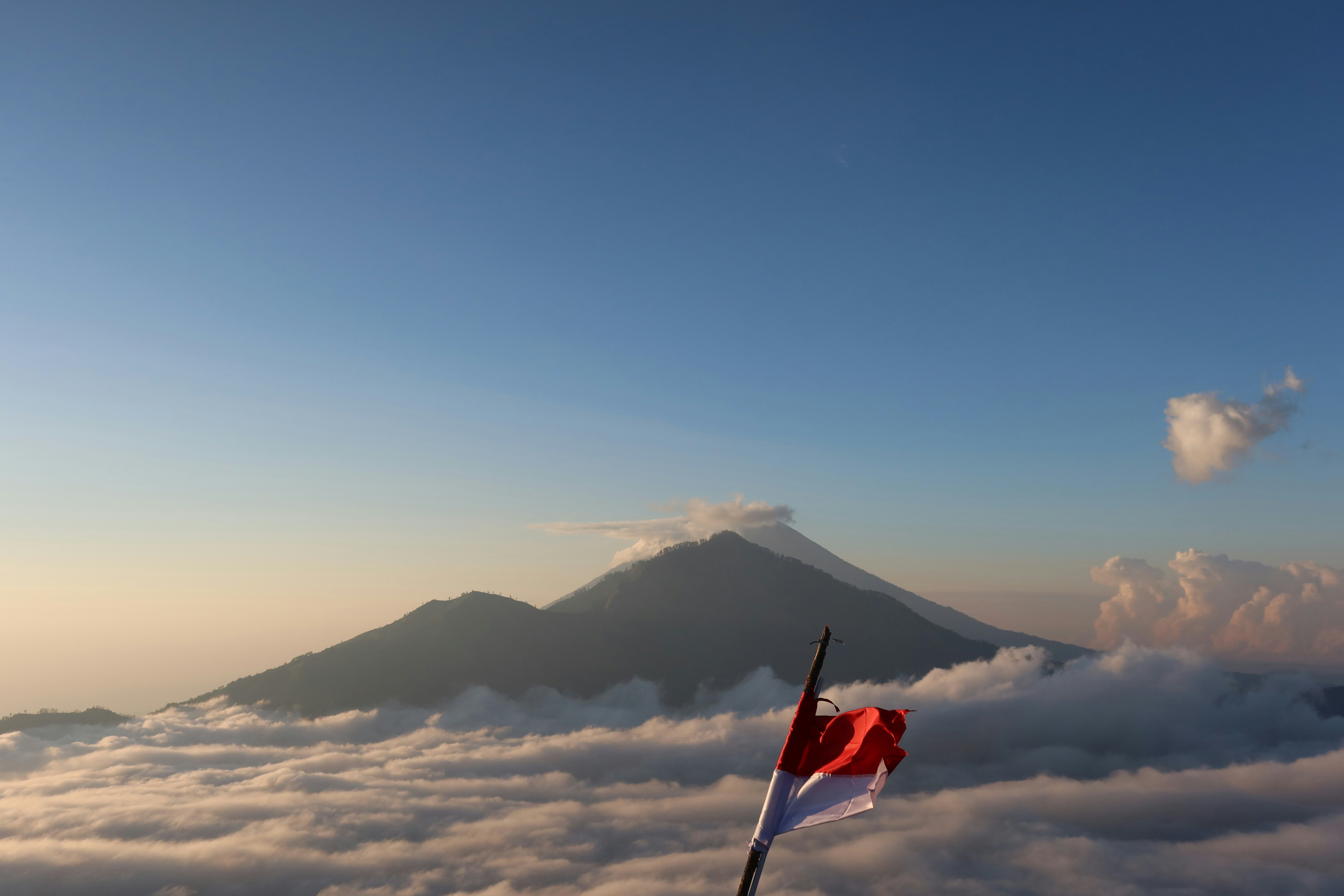 Flag over a cloud-swept volcano at dawn