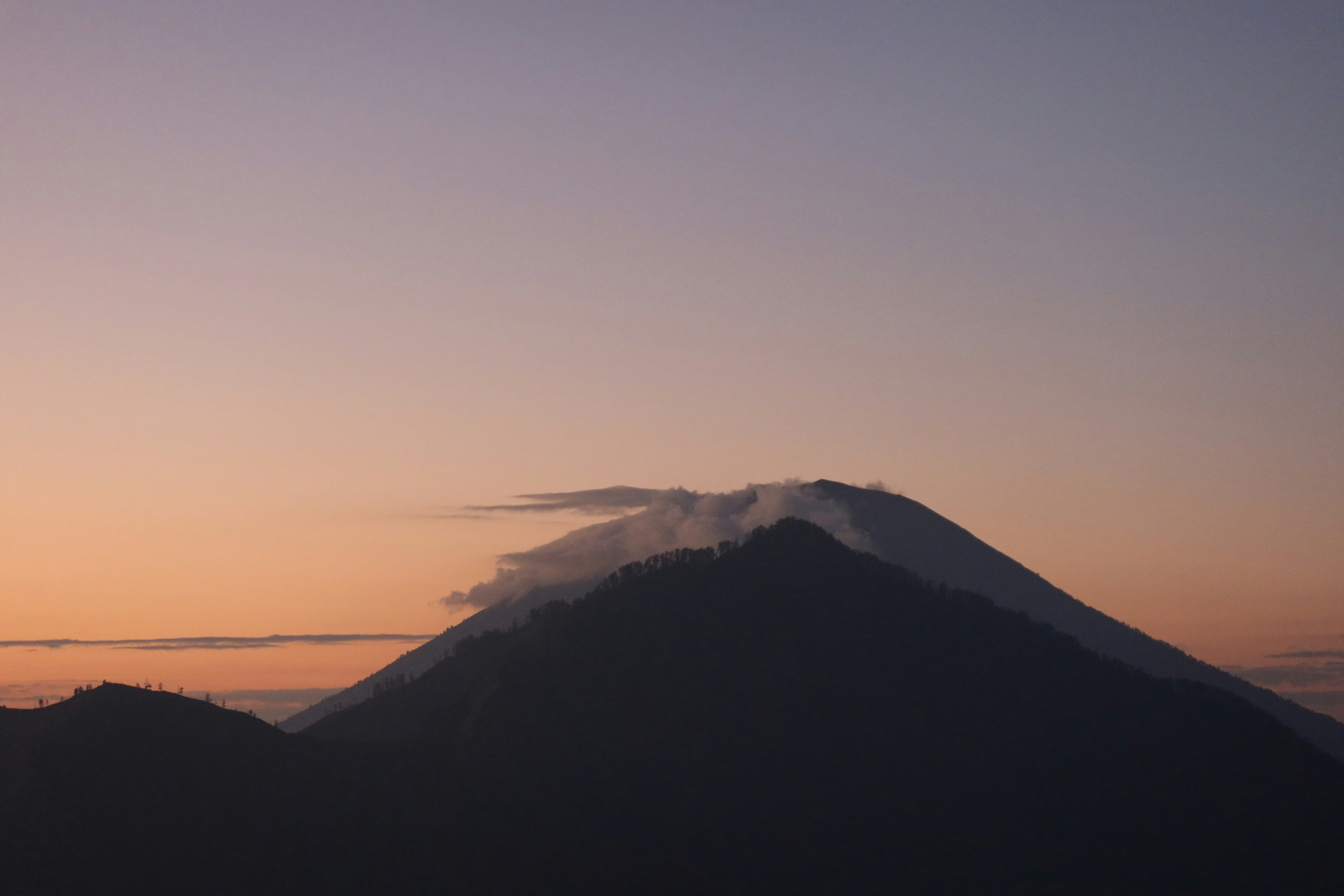 Dusk Summit: A Quiet Silhouette Beneath the Orange Sky