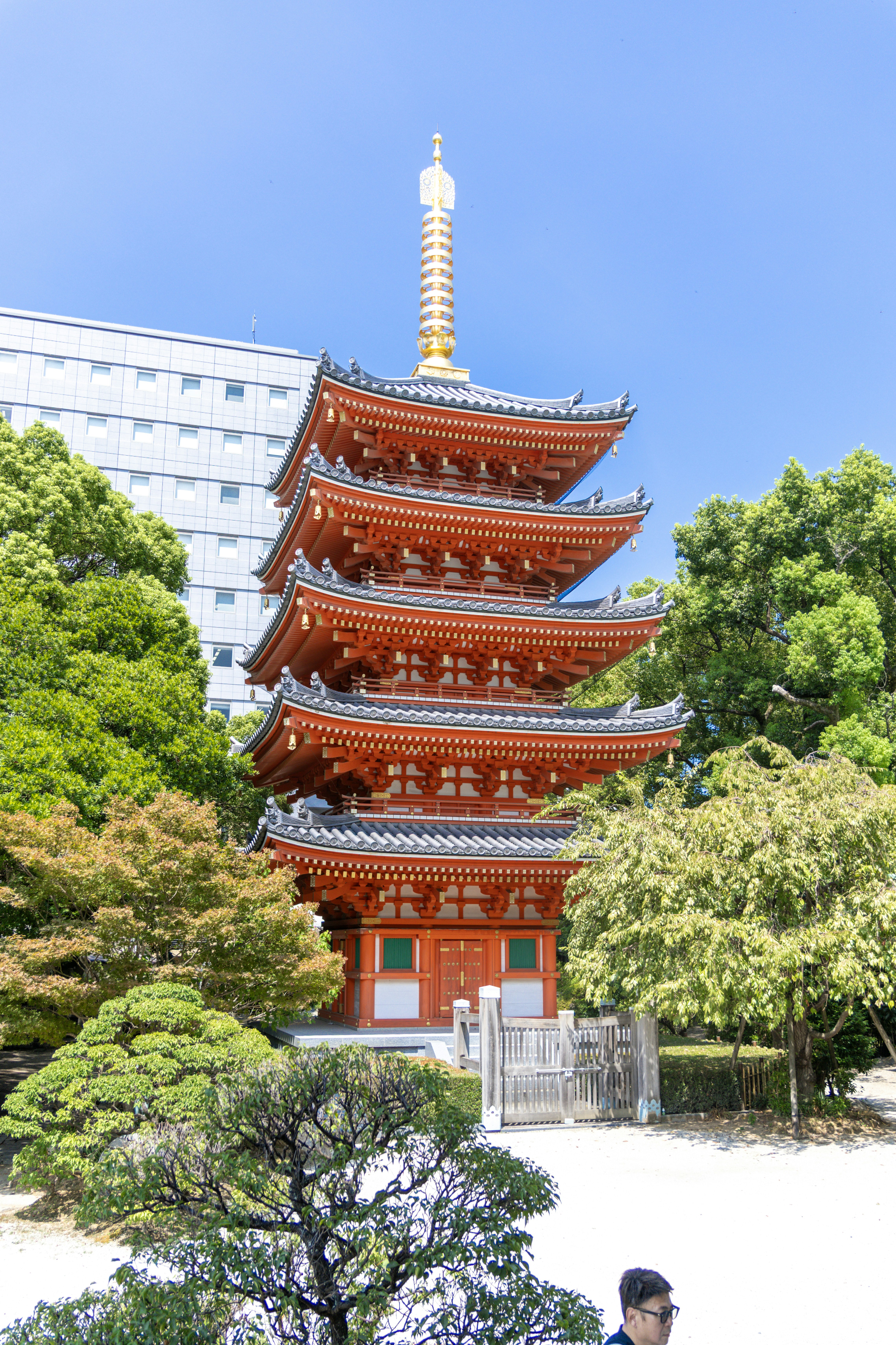 Red Pavilion in a Green Courtyard Under a Clear Sky