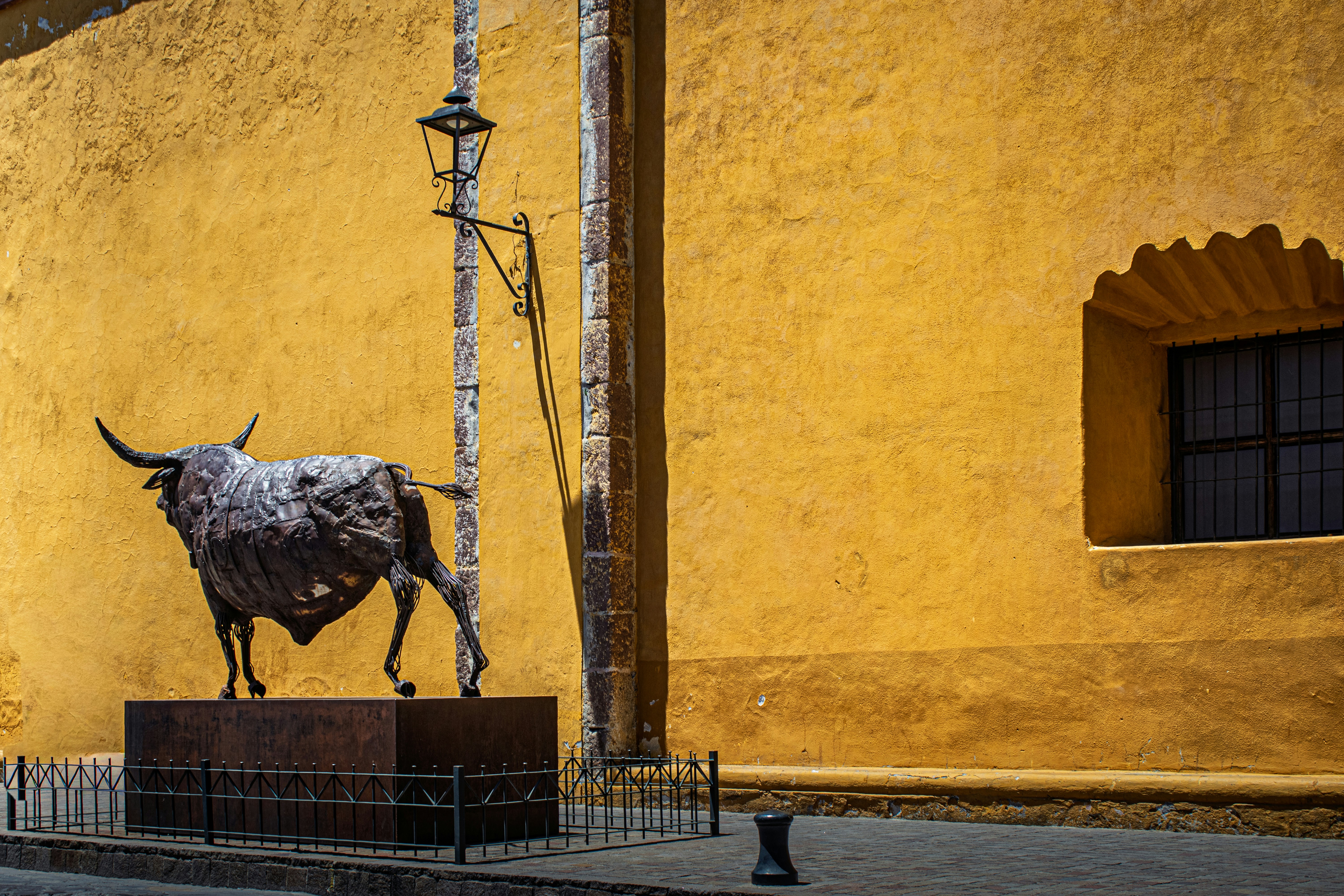 Yellow-walled Square: Bronze Bull Stands Guard by the Window