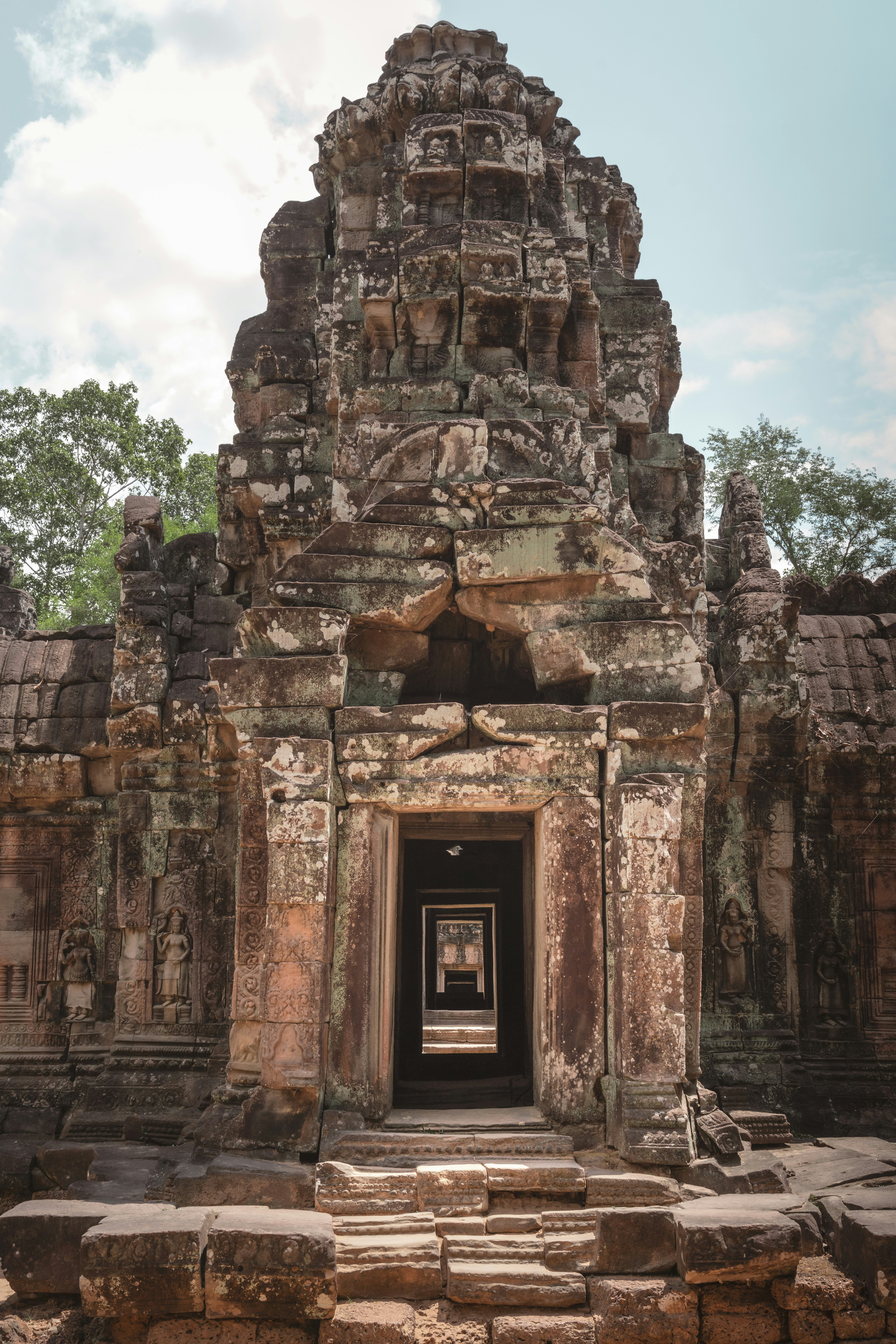 Temple gate receding into dim passage: a sandstone ascent toward inner sanctum