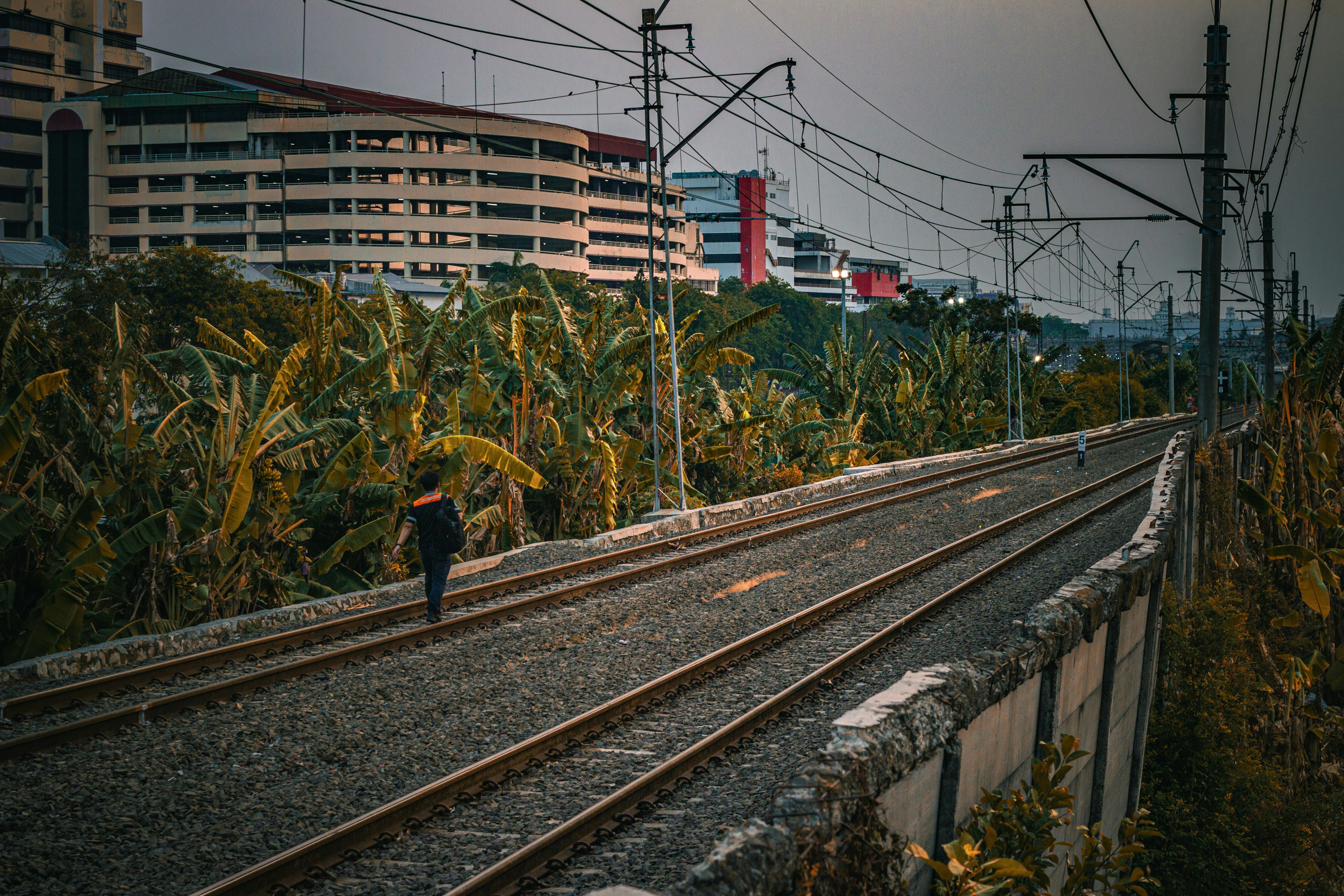 Runner on the Rails Amidst a City Fringed Corridor