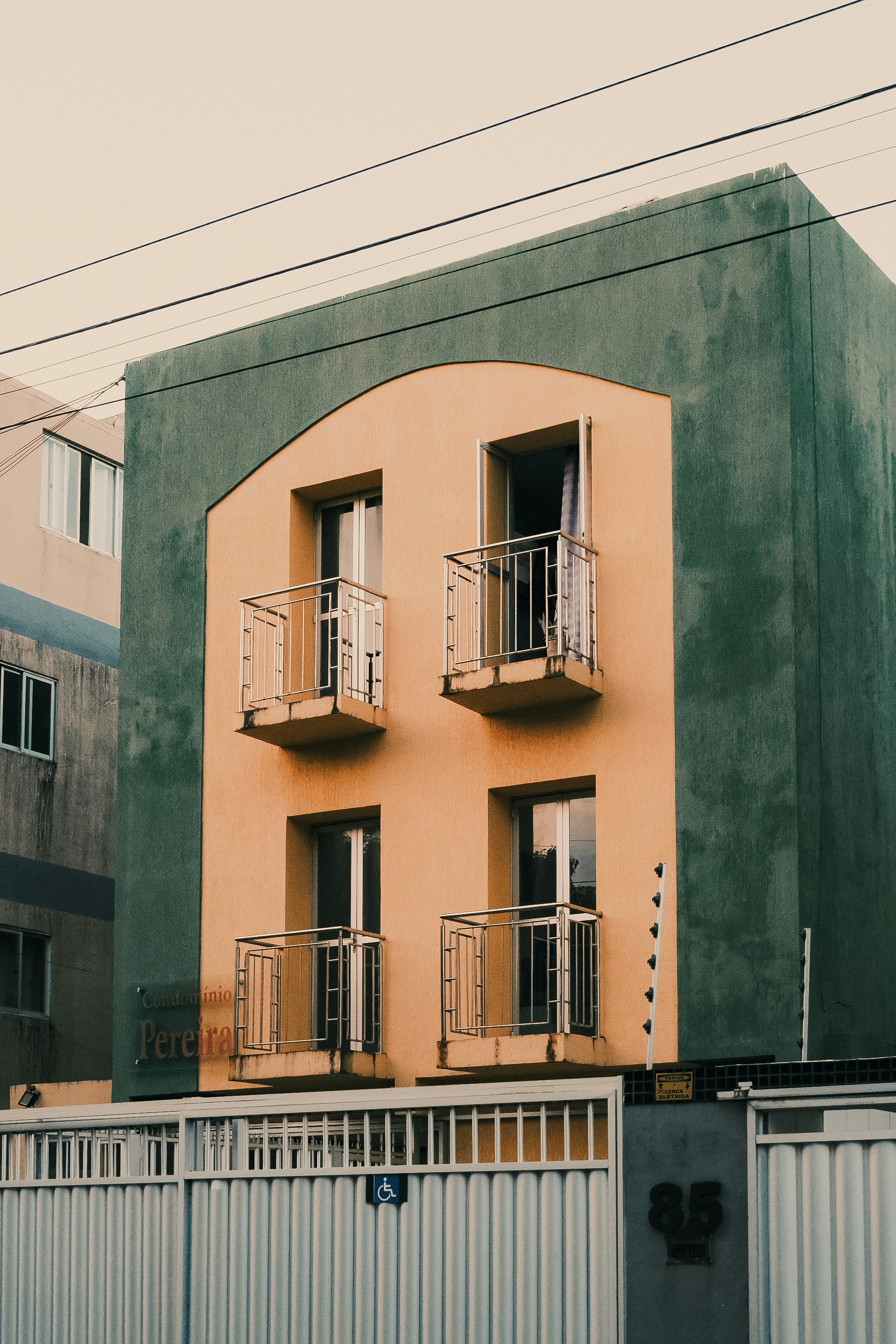 -peach-tinted apartment facade with four balconies-