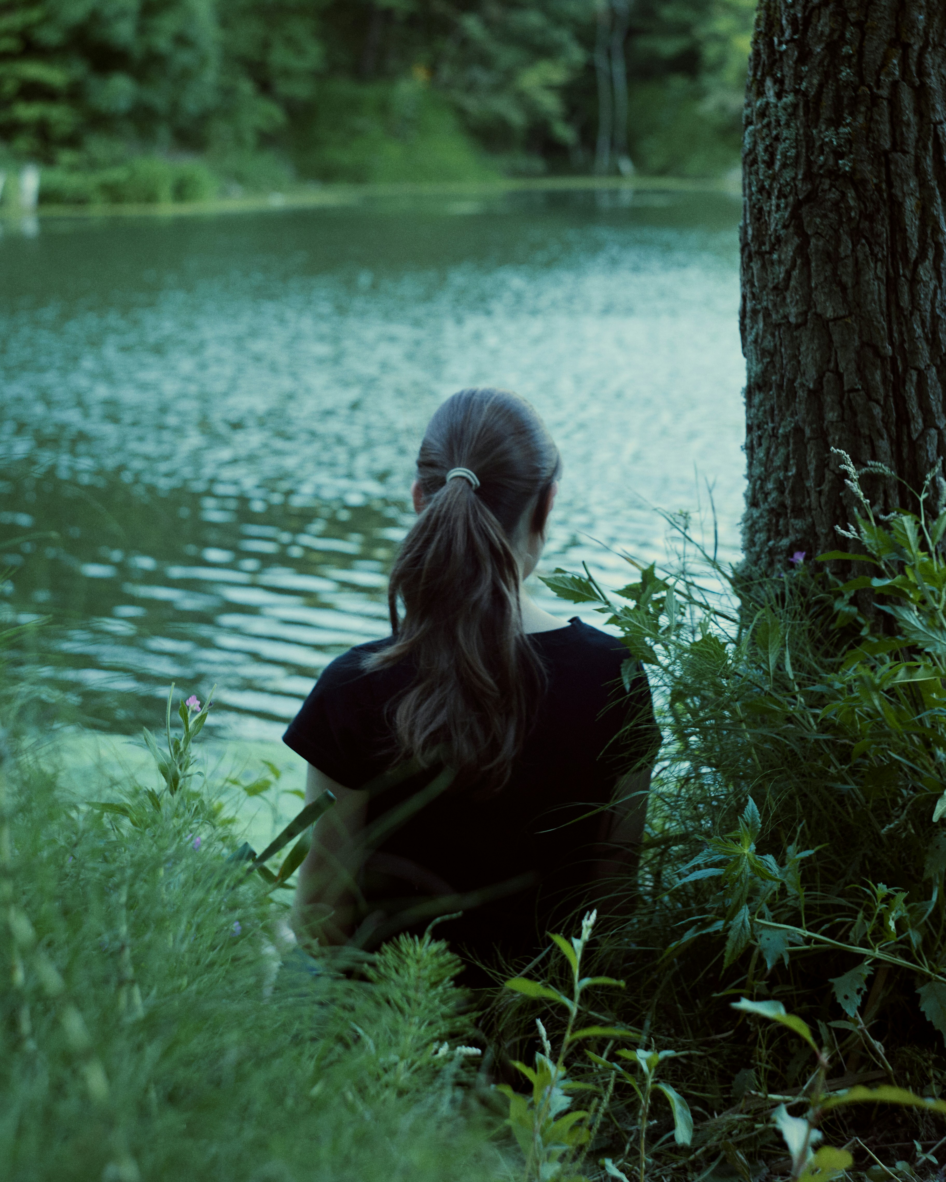 Quiet Anchor by the Water: A Woman with Ponytail in Shadowed Verge