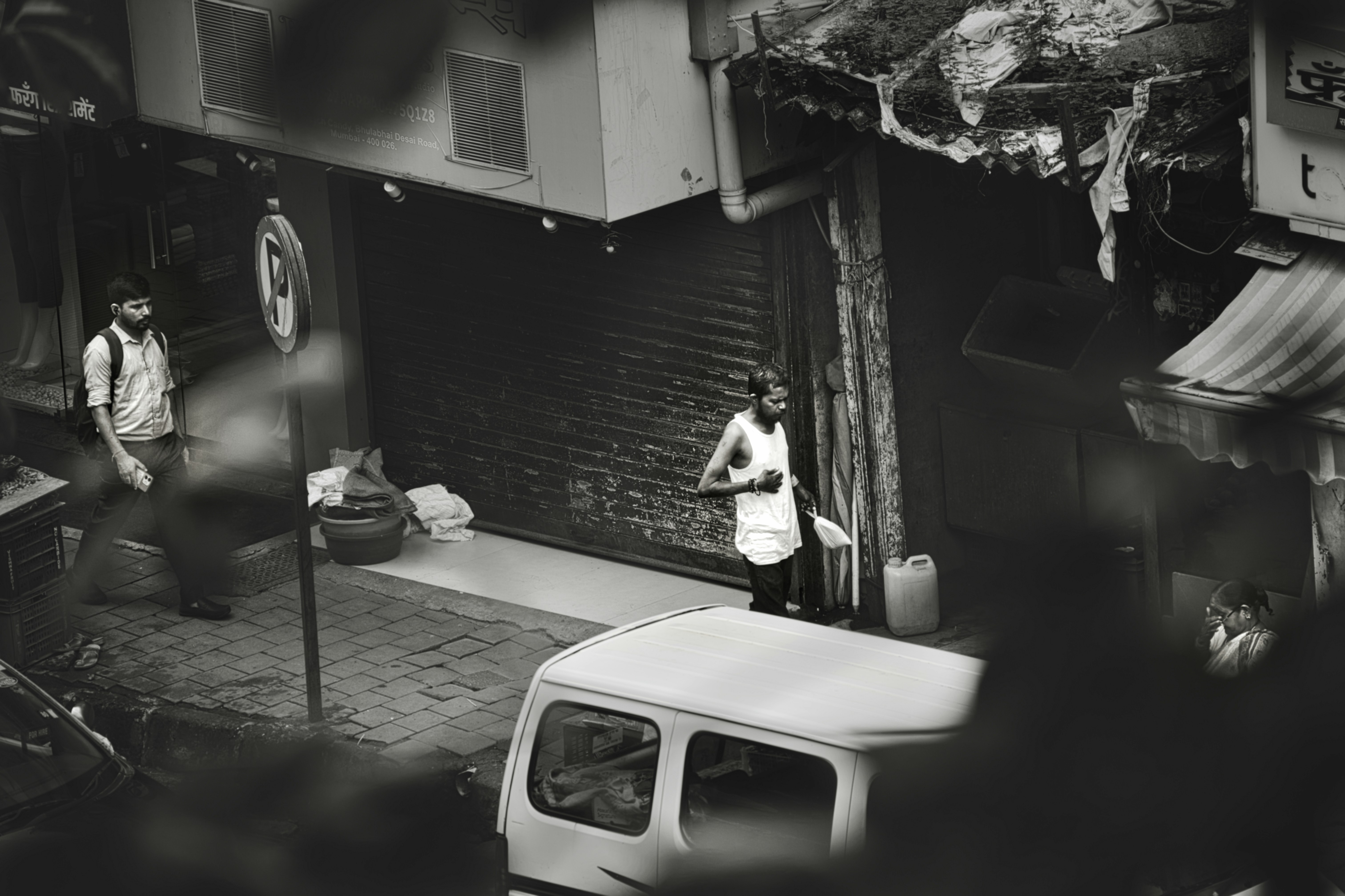 Two pedestrians cross the same frame in harmony — the small choreography of a city street caught mid-motion.