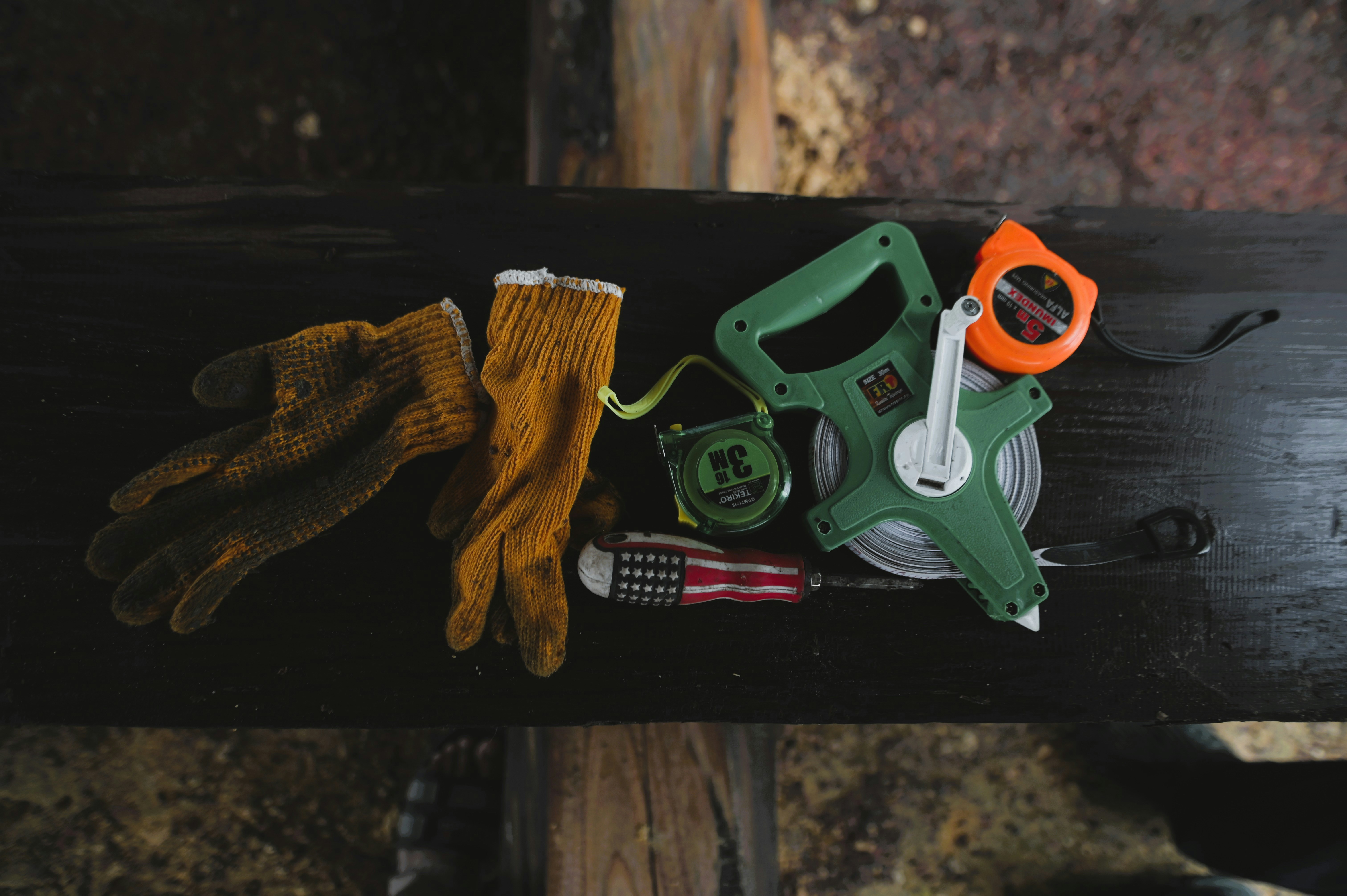 Workbench Tools: Gloves, Tape Measure, and Utility Instrumentation Rest on a Dark Beam