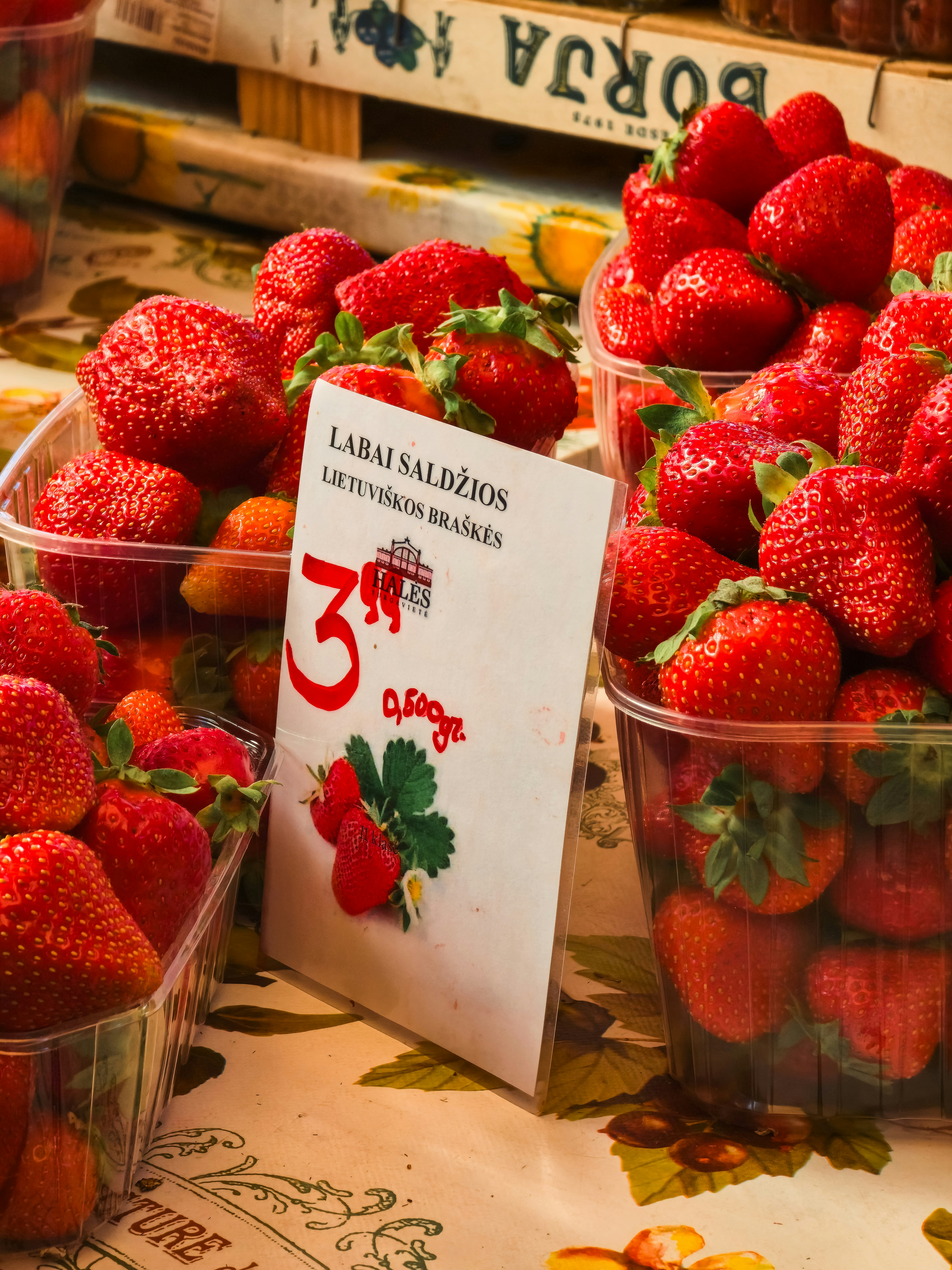 Vibrant Strawberry Market Card Leaning among Fresh Baskets