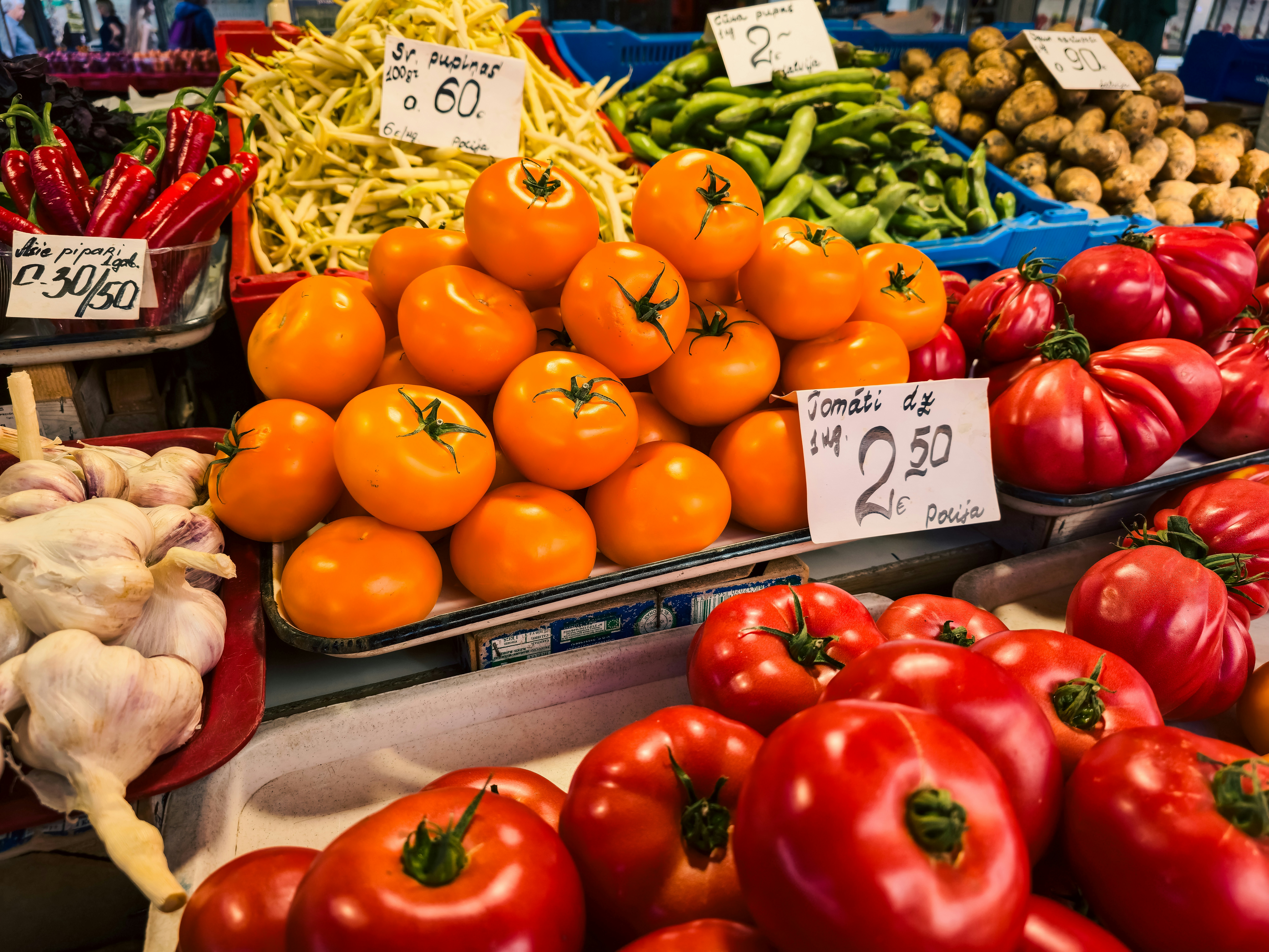 Pile of Sun-Kissed Tomatoes and Red Bells at a Busy Market