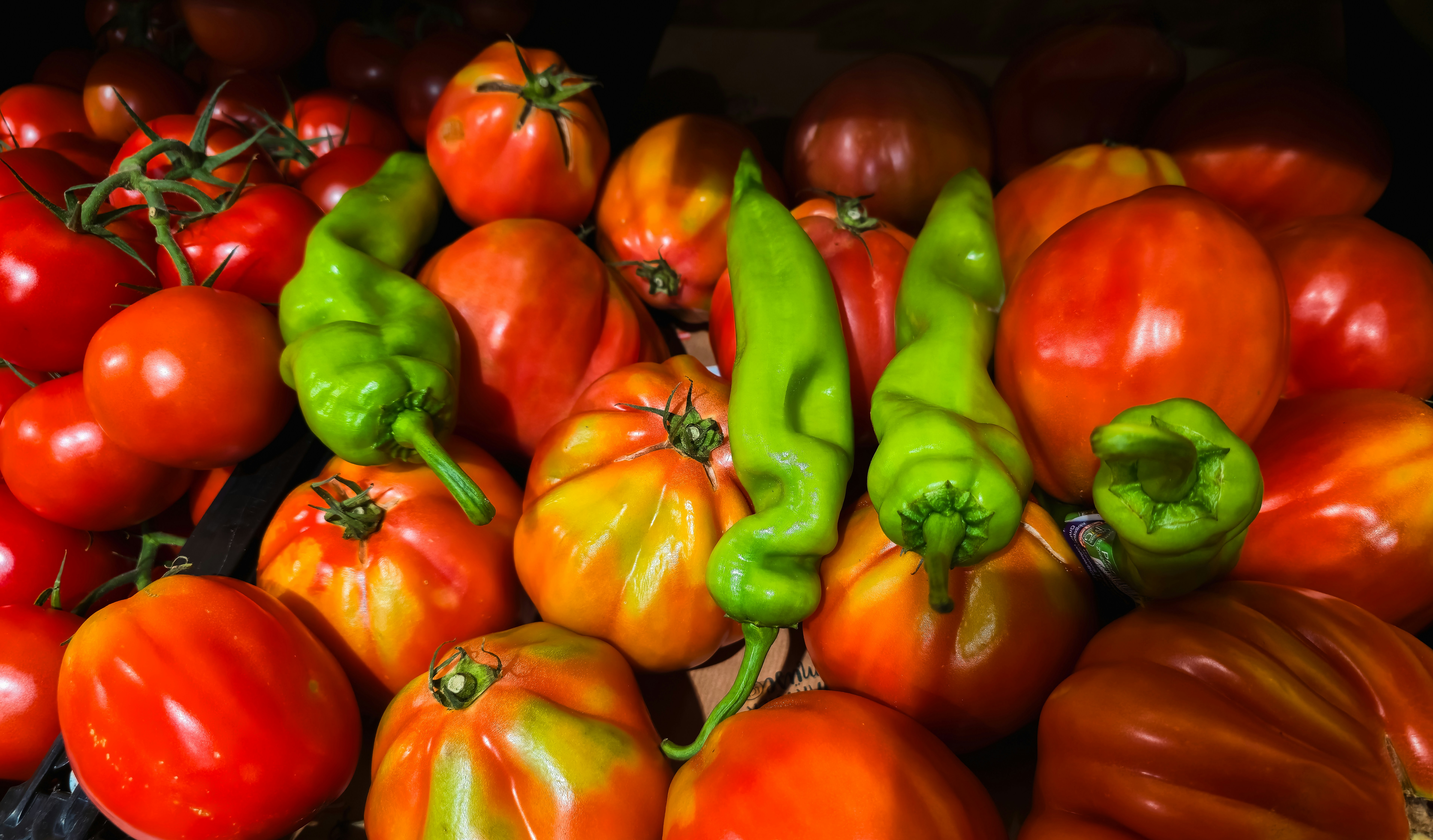 Basket of Fiery Tomatoes and Green Peppers Under Soft Lighting