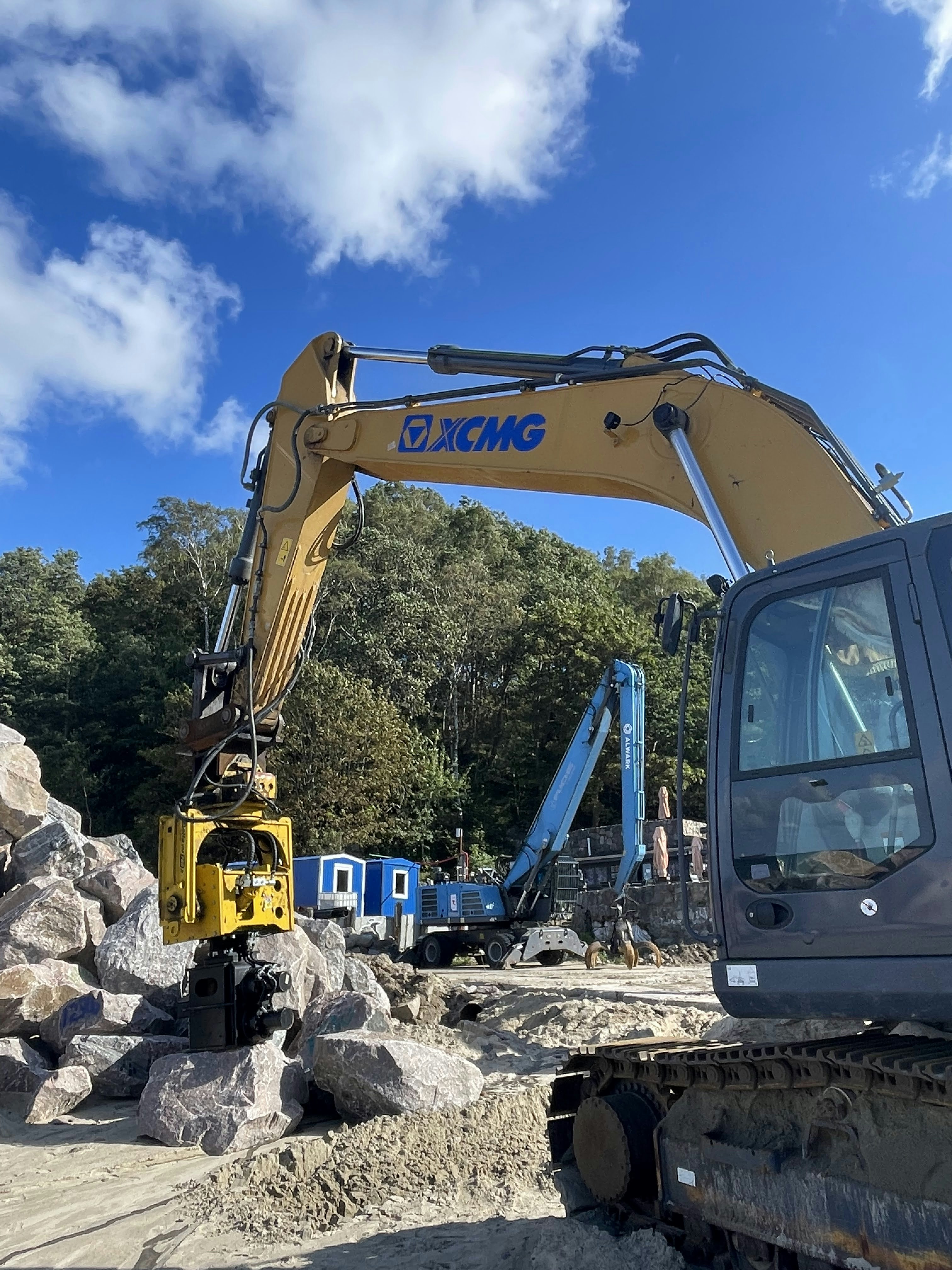 Heavy Lifting: Excavator Arm Framing a Quarry Under Bright Sky