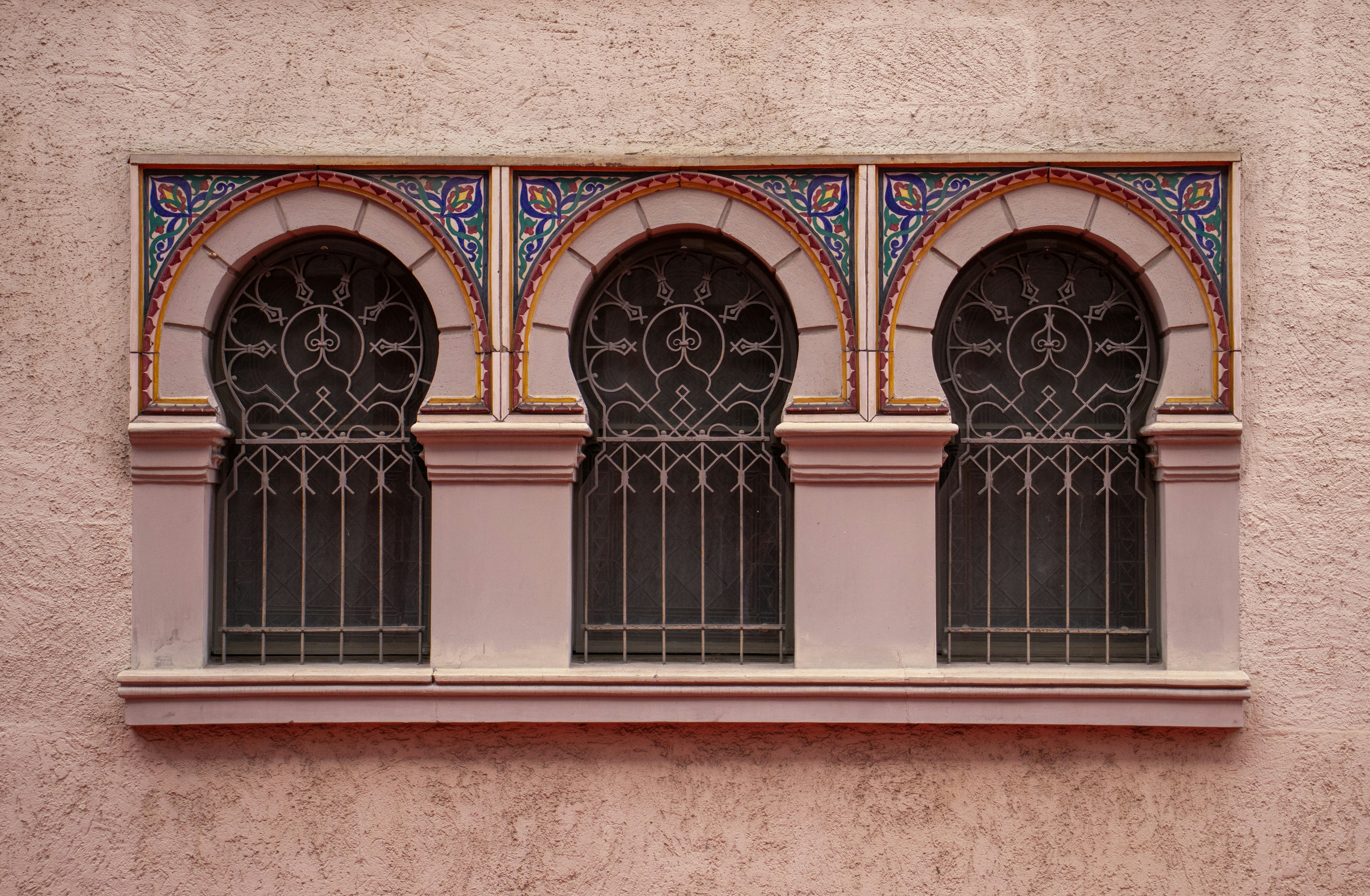 Three Arched Windows with Decorative Tilework on Pink Facade
