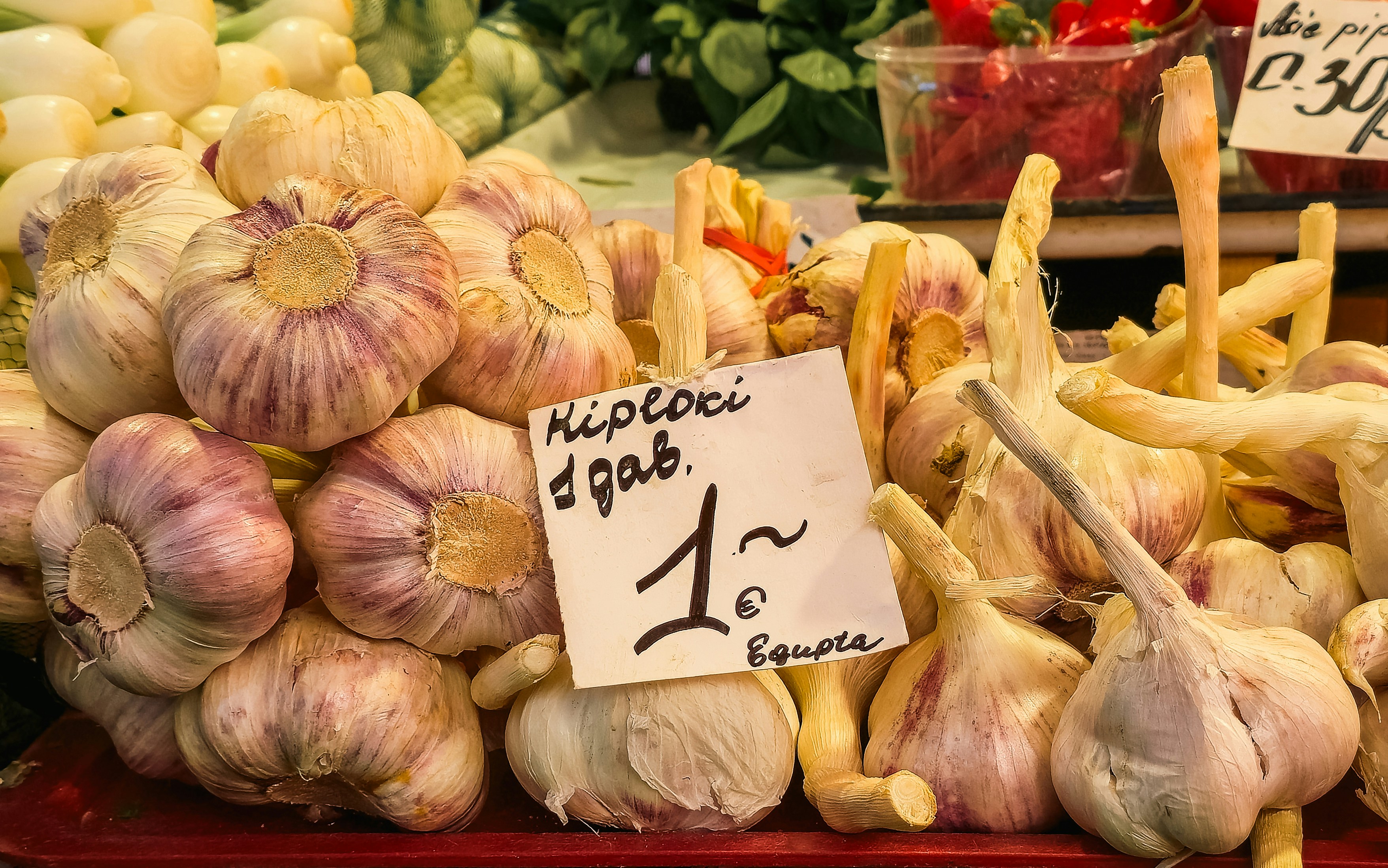 Garlic Market Buzz: A Heap of Fresh Bulbs with a Handwritten Price Tag