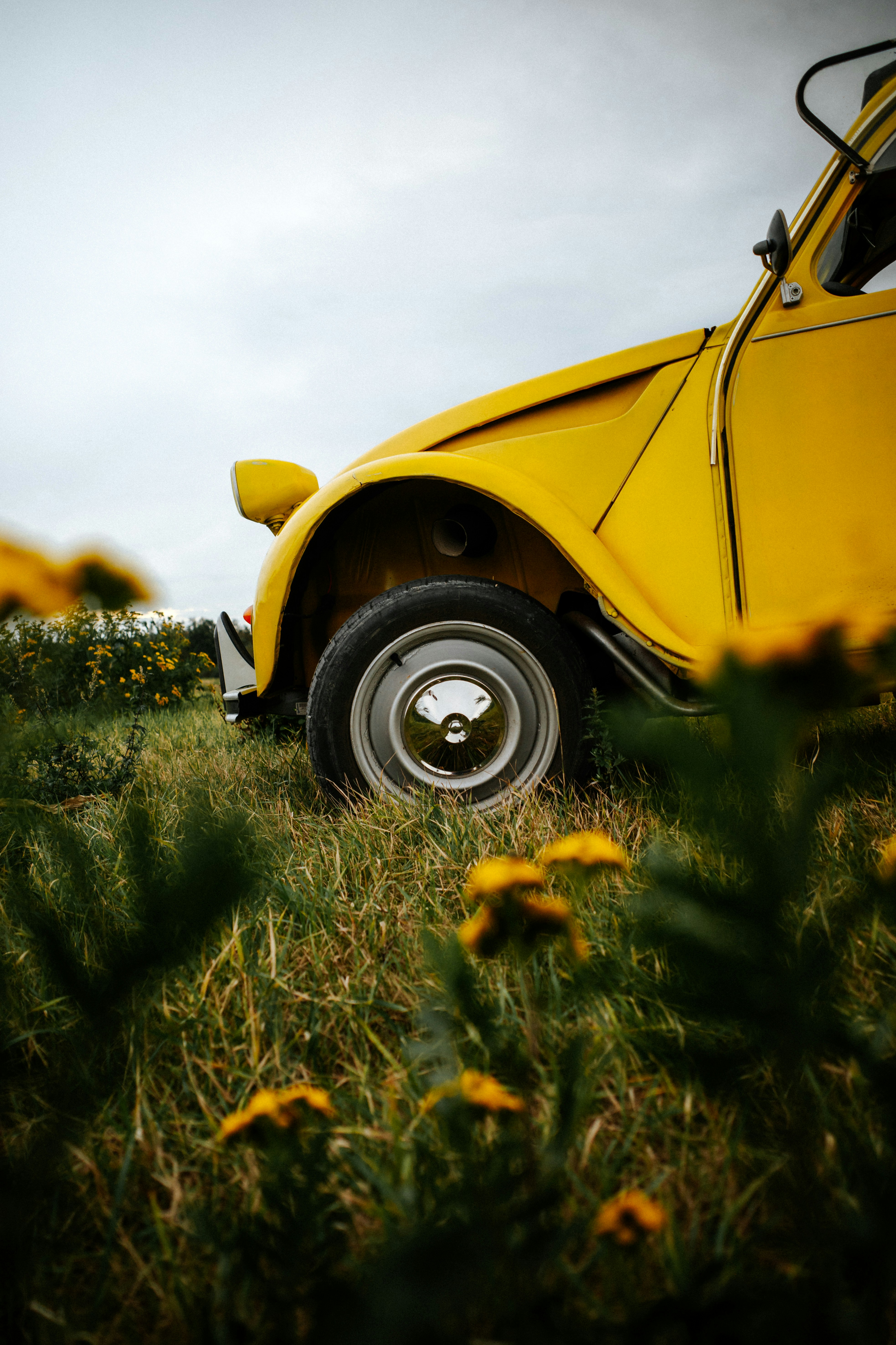Bright Yellow Classic: A Vintage Vehicle Resting in a Field