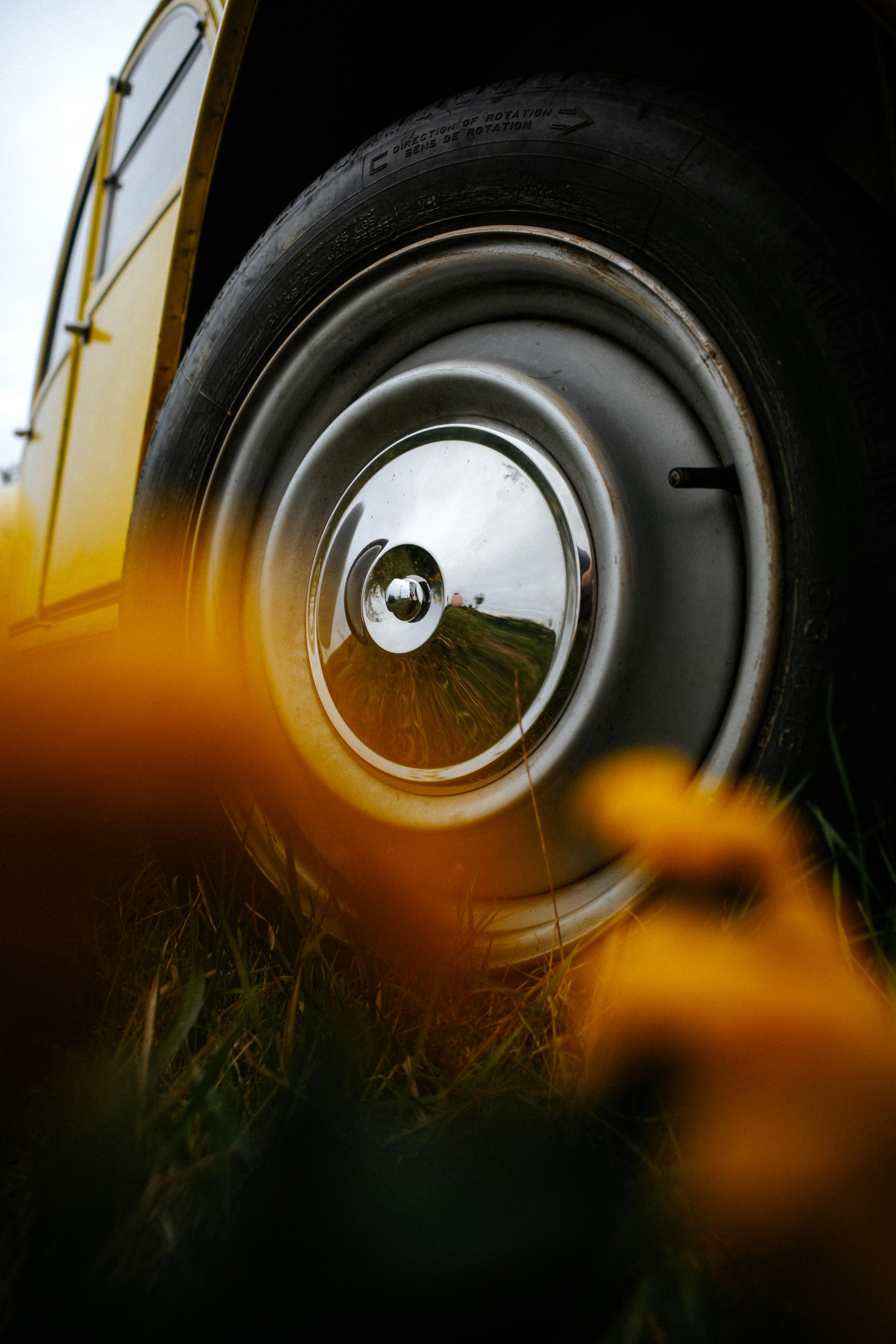 Yellow bus wheel in focus with blurred foreground bloom