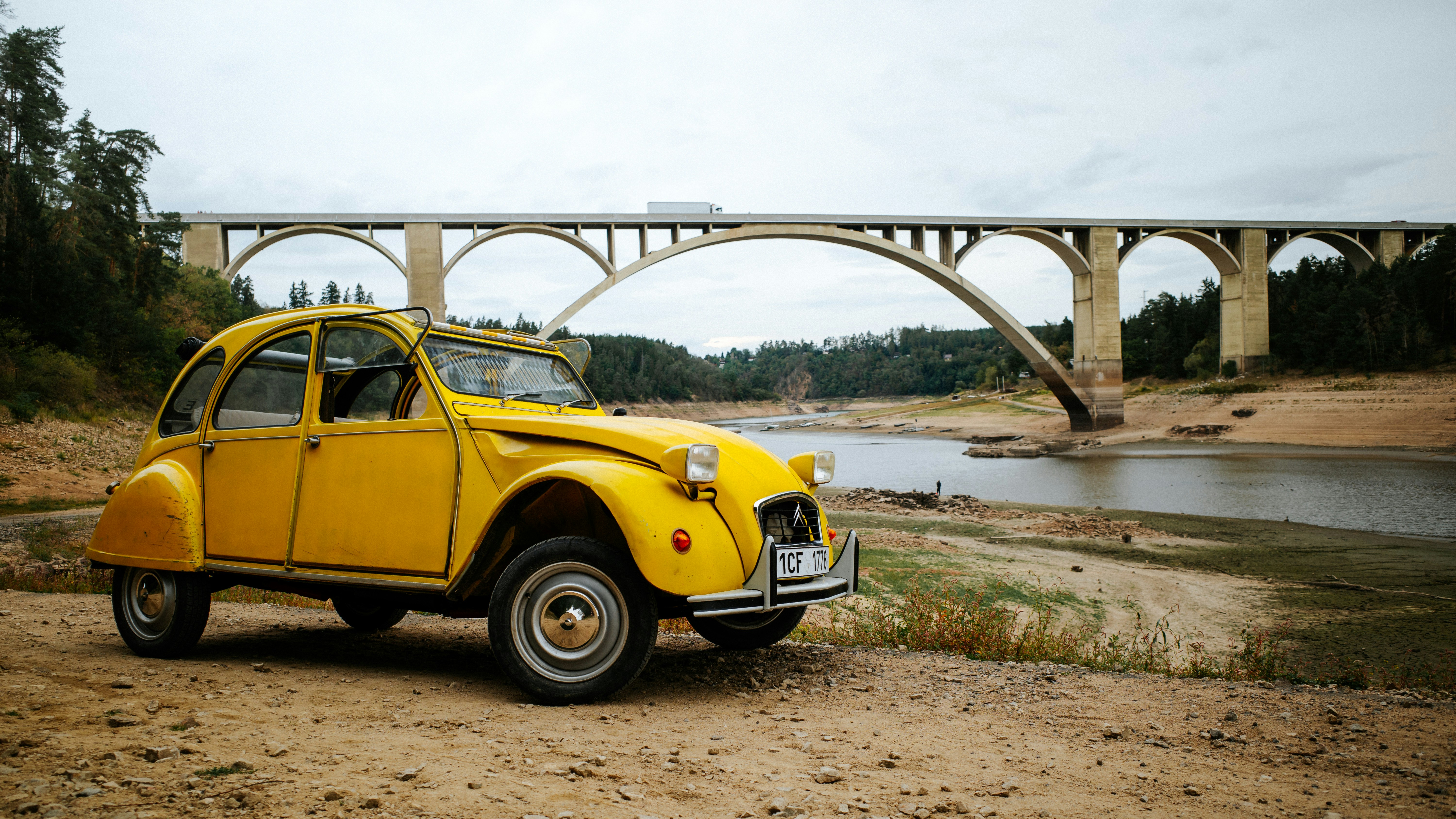 Yellow Classic Under the Arches: A Lone Car By the River