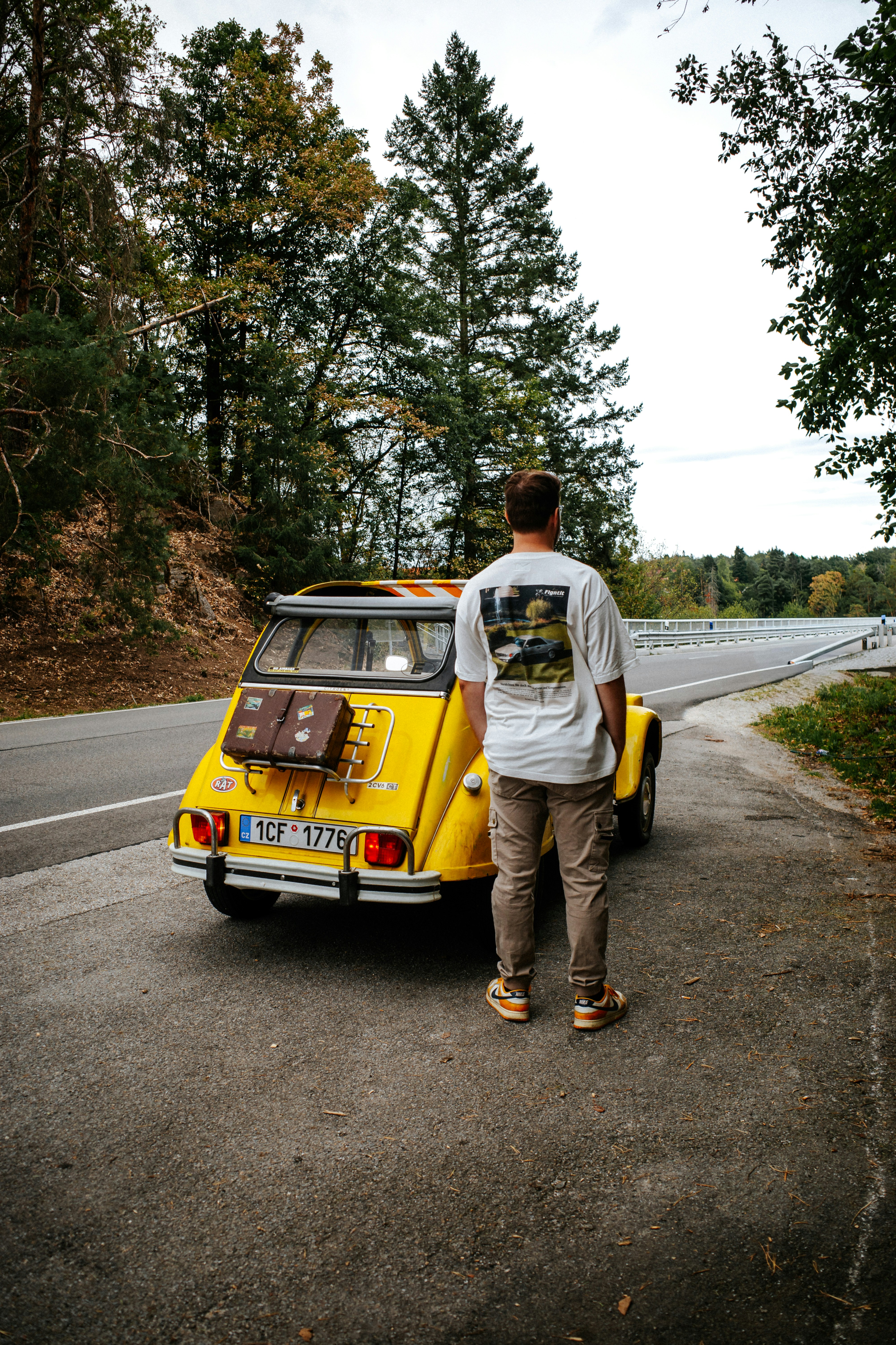 Yellow Roadside Echo: A Traveler and a Vintage Beetle in Transit
