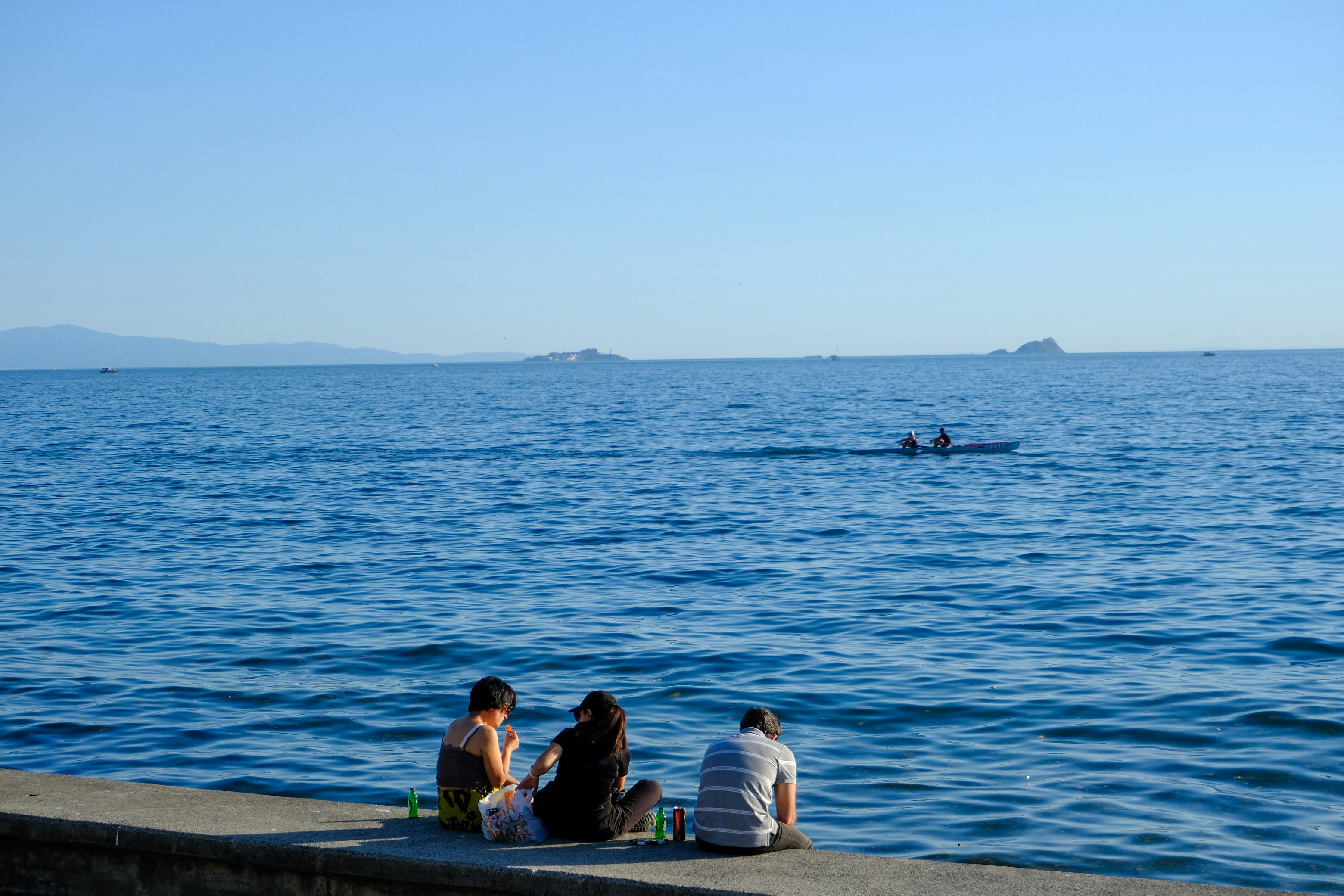 Coastal Quiet: Friends by the Pier as the Sea Breathes Blue