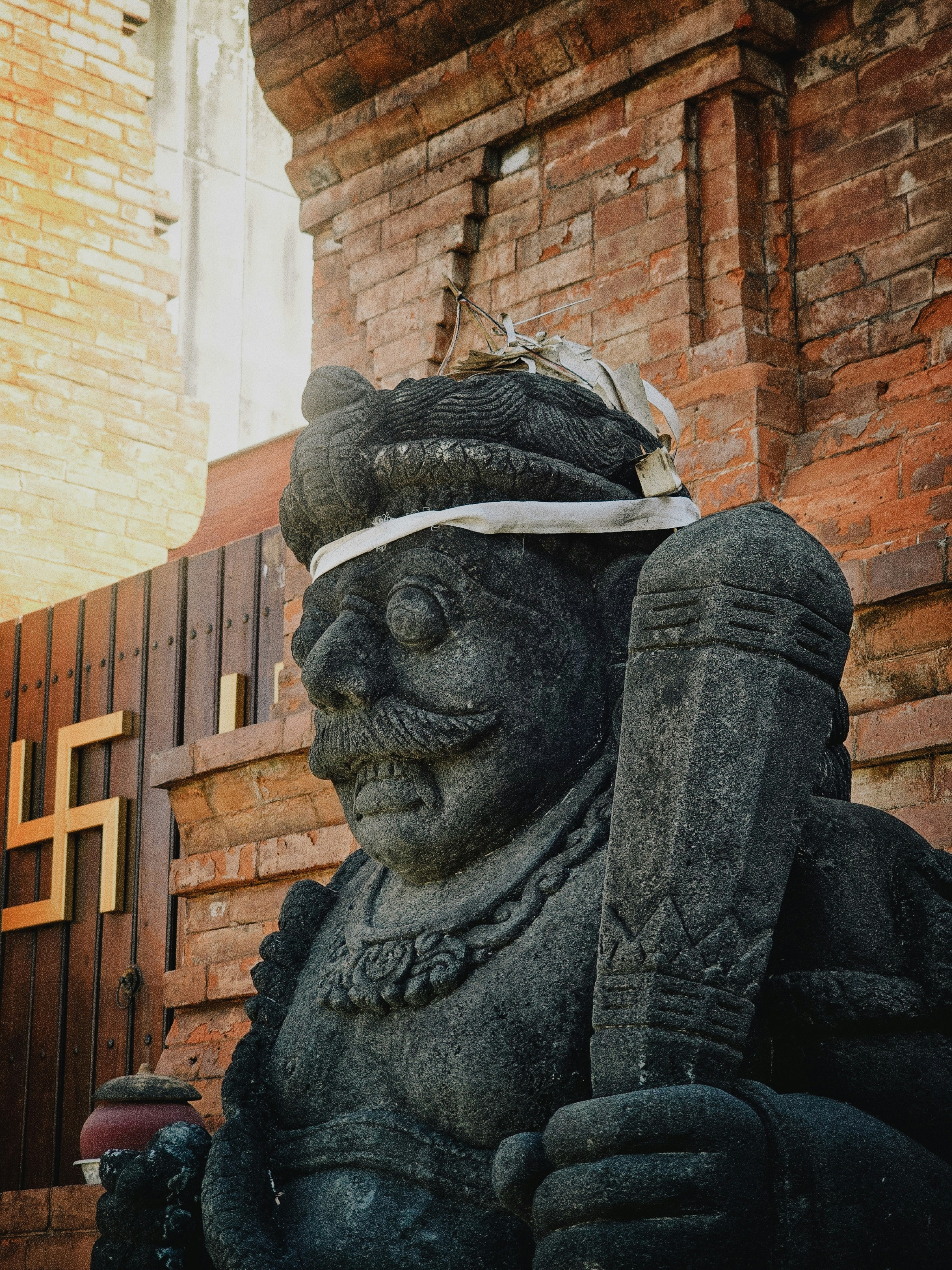 Stone Guardian with Wrapped Bandana under Brick Arch
