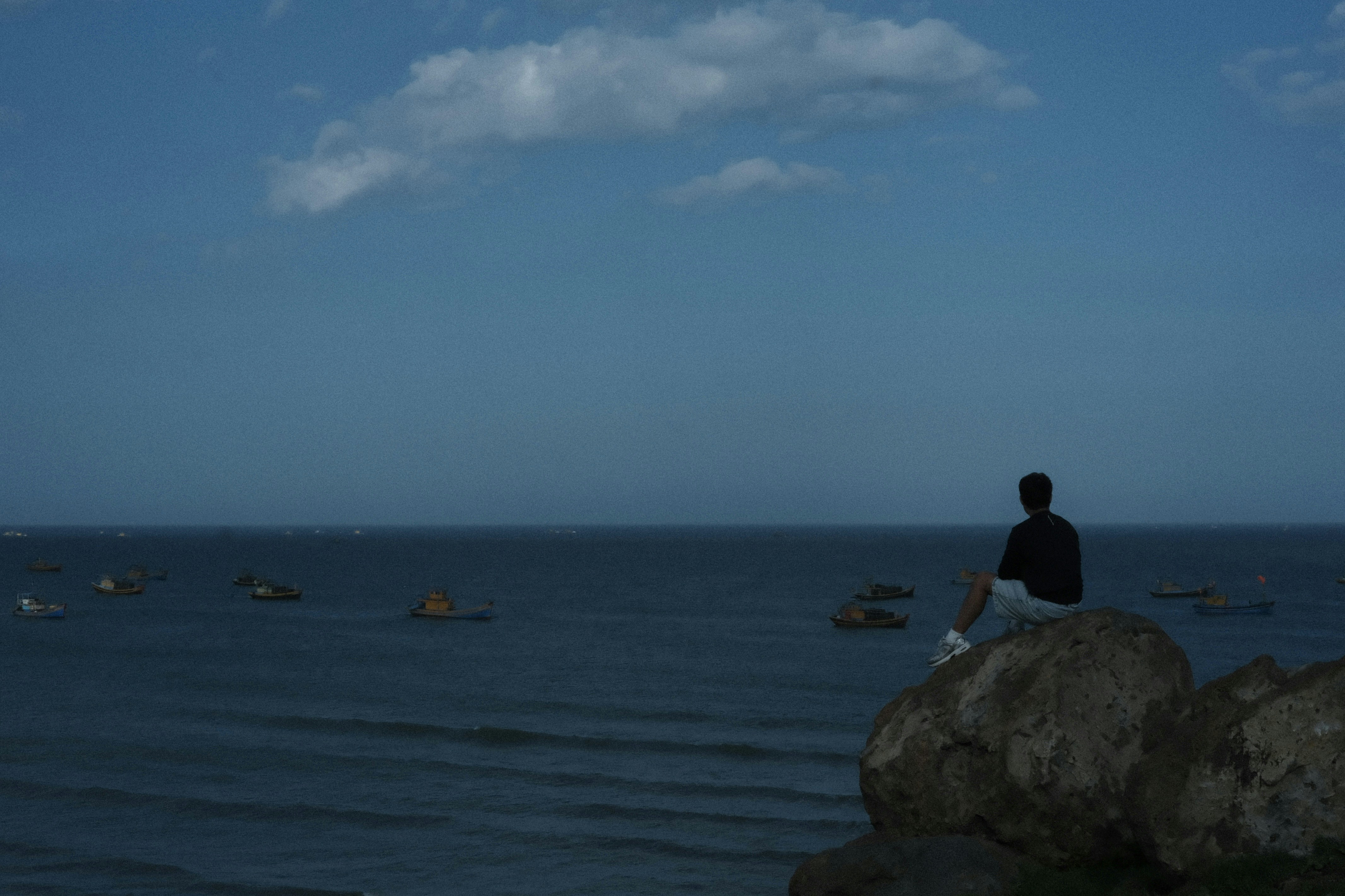 A Seated Silhouette on the Sea-Born Cliff