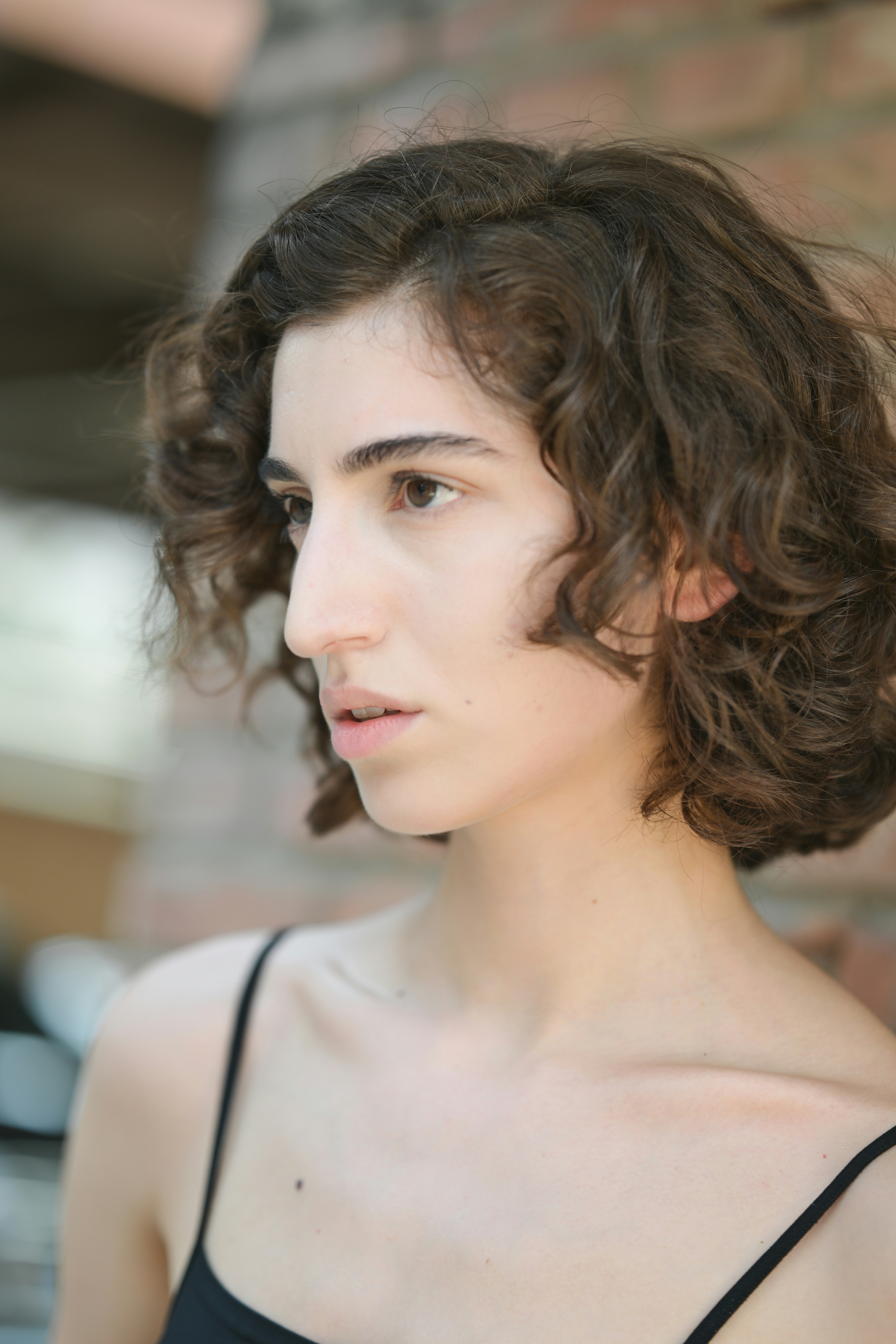 Soft Focus Portrait: A contemplative gaze against a brick backdrop