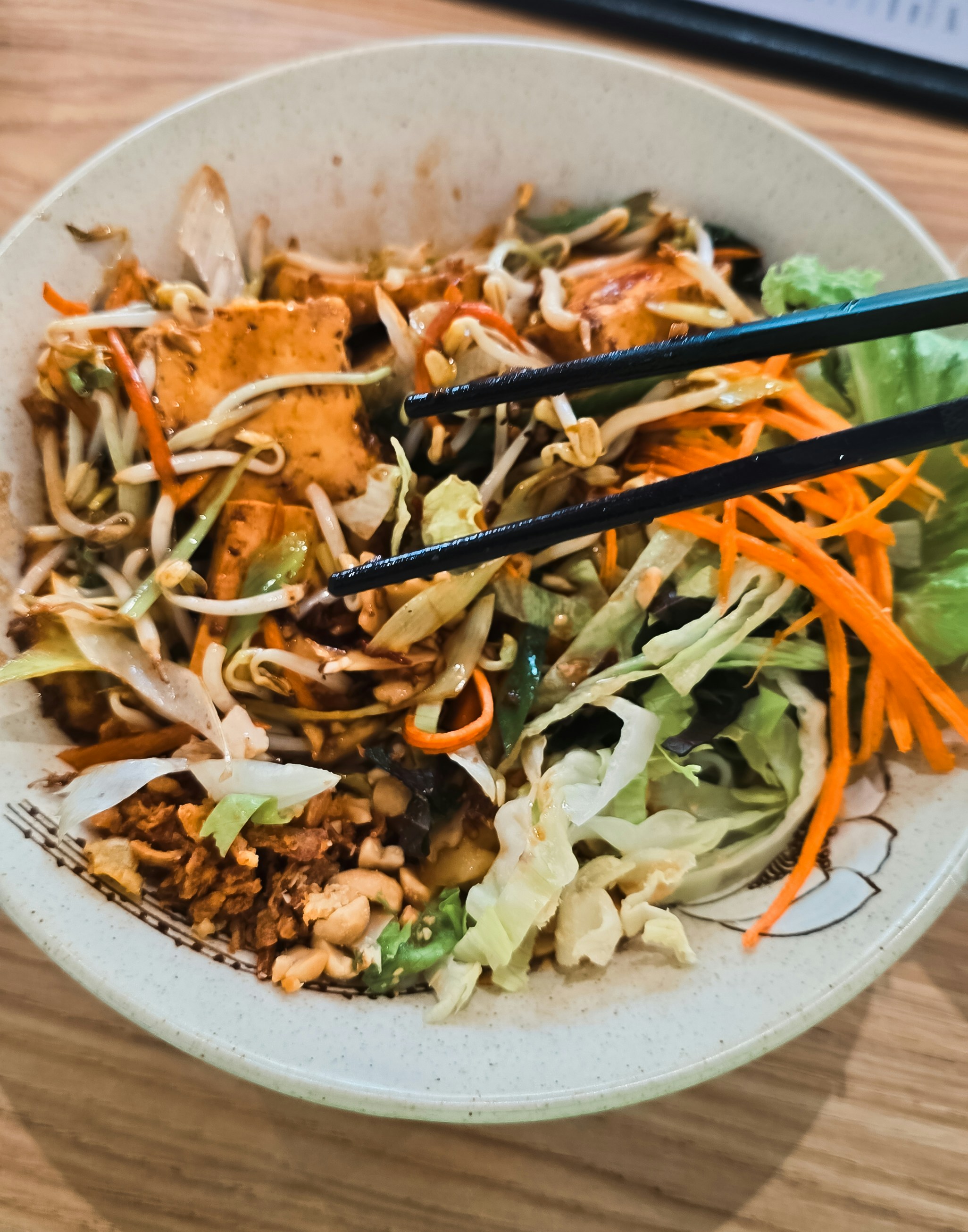 Chopstick Gesture Over a Vibrant Bowl of Stir-Fried Veg & Tofu