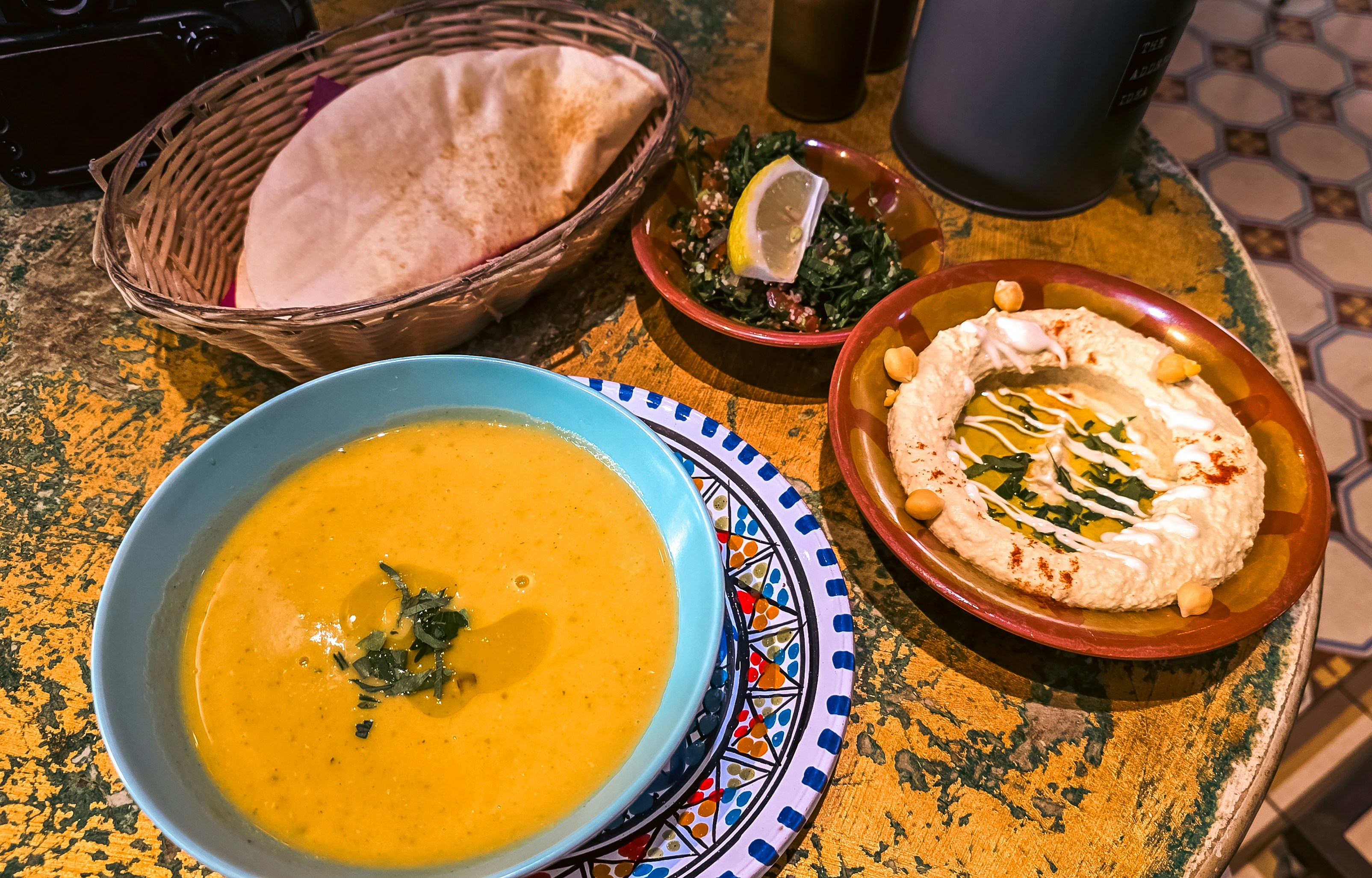 Colorful Bowl of Comfort: Creamy Soup and Hummus Spread on a Rustic Table