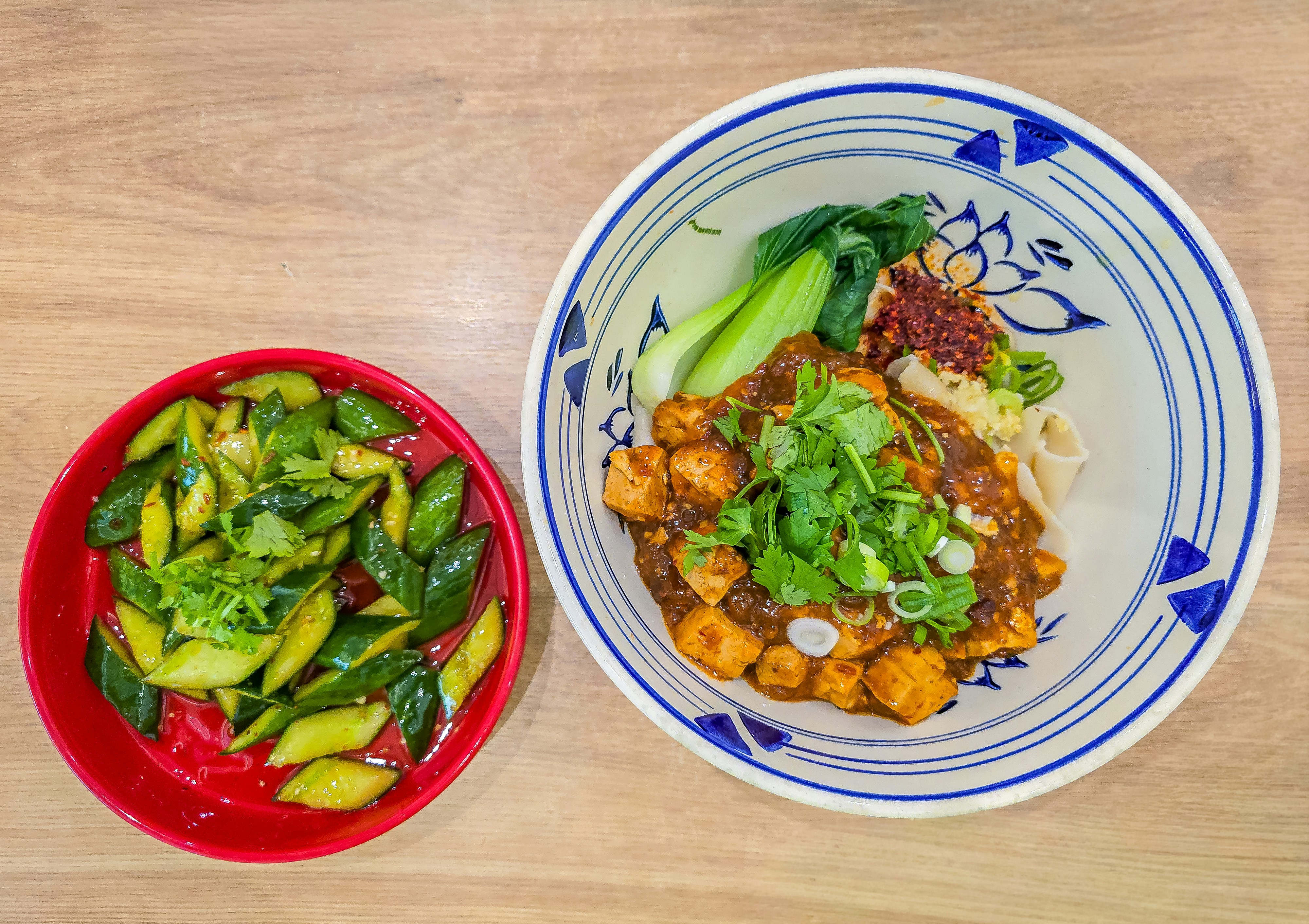 Twin Bowls of Flavor: Spicy Tofu in a Cerulean Rim and Crispy Greens