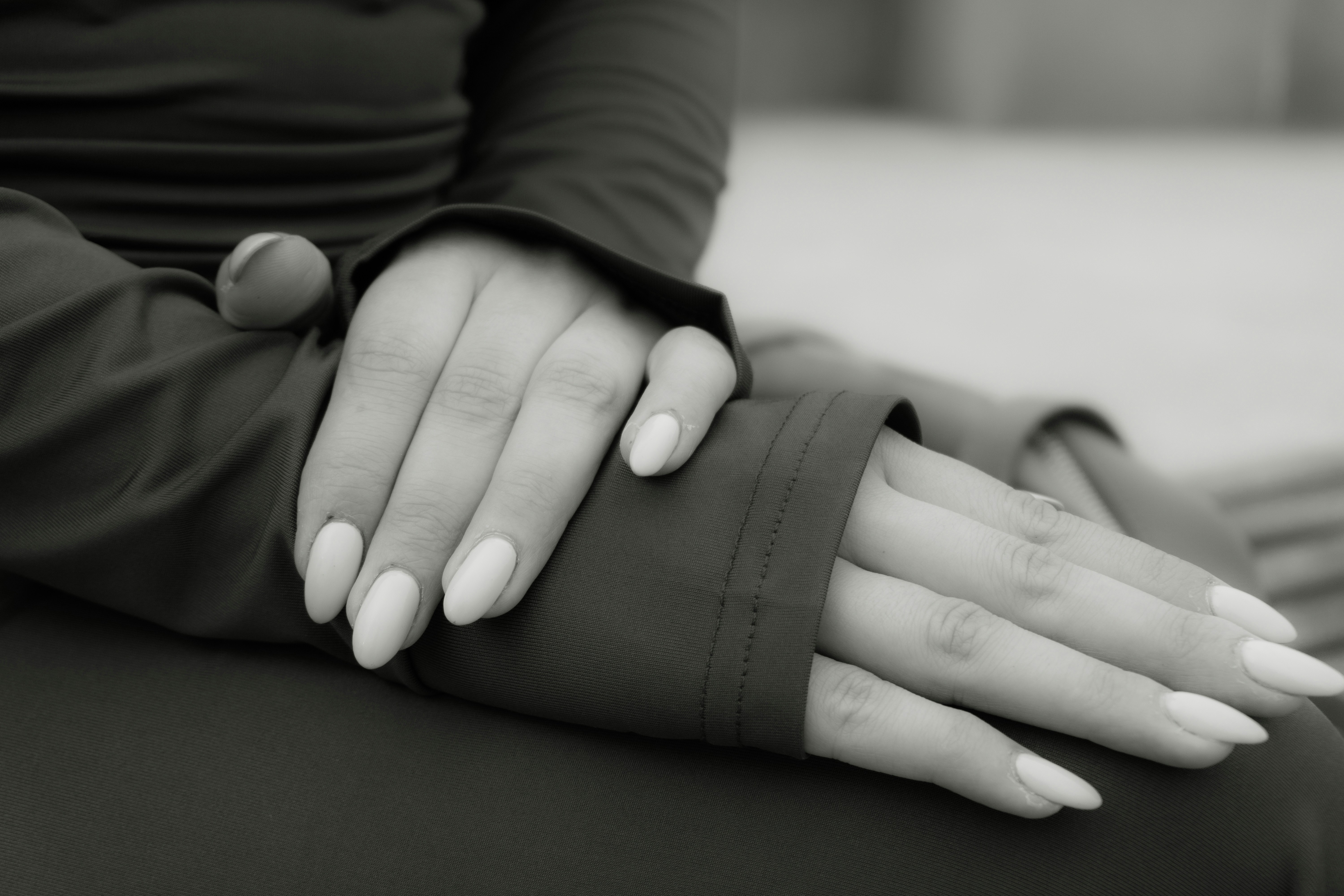 Interlaced Silence: Close–Up of Hands on Dark Fabric