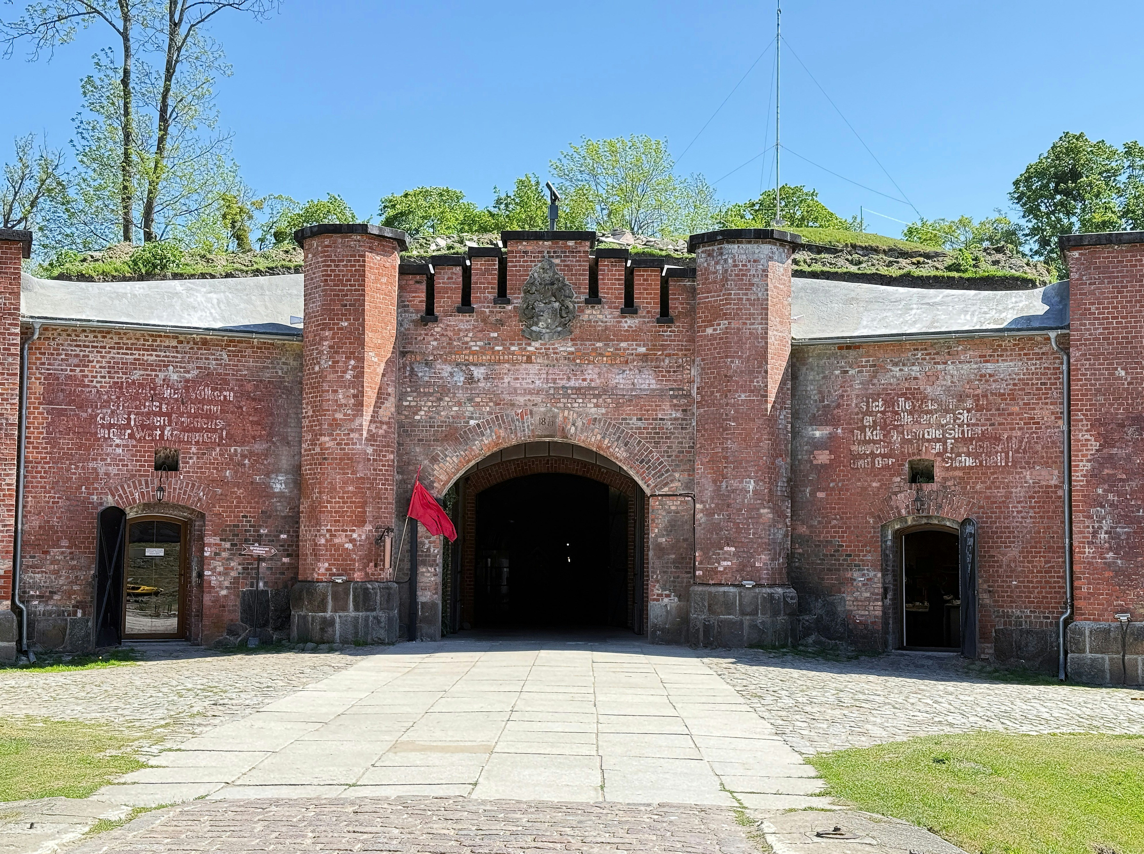 Brick Fortress Gate: Sunlit Courtyard Leads to a Dark Arch
