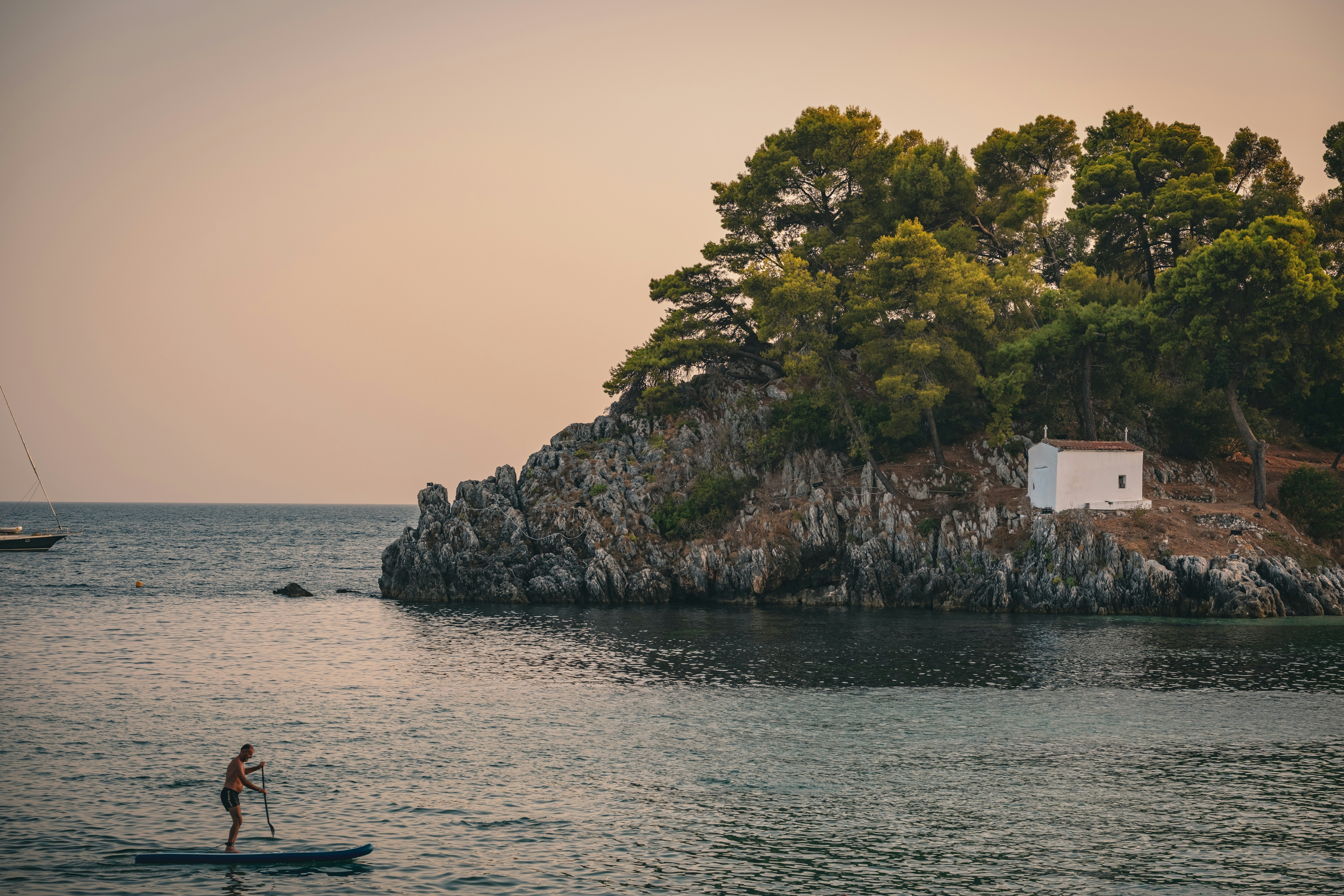 Harbor Silence: A Lone Paddle under a Rocky Promontory