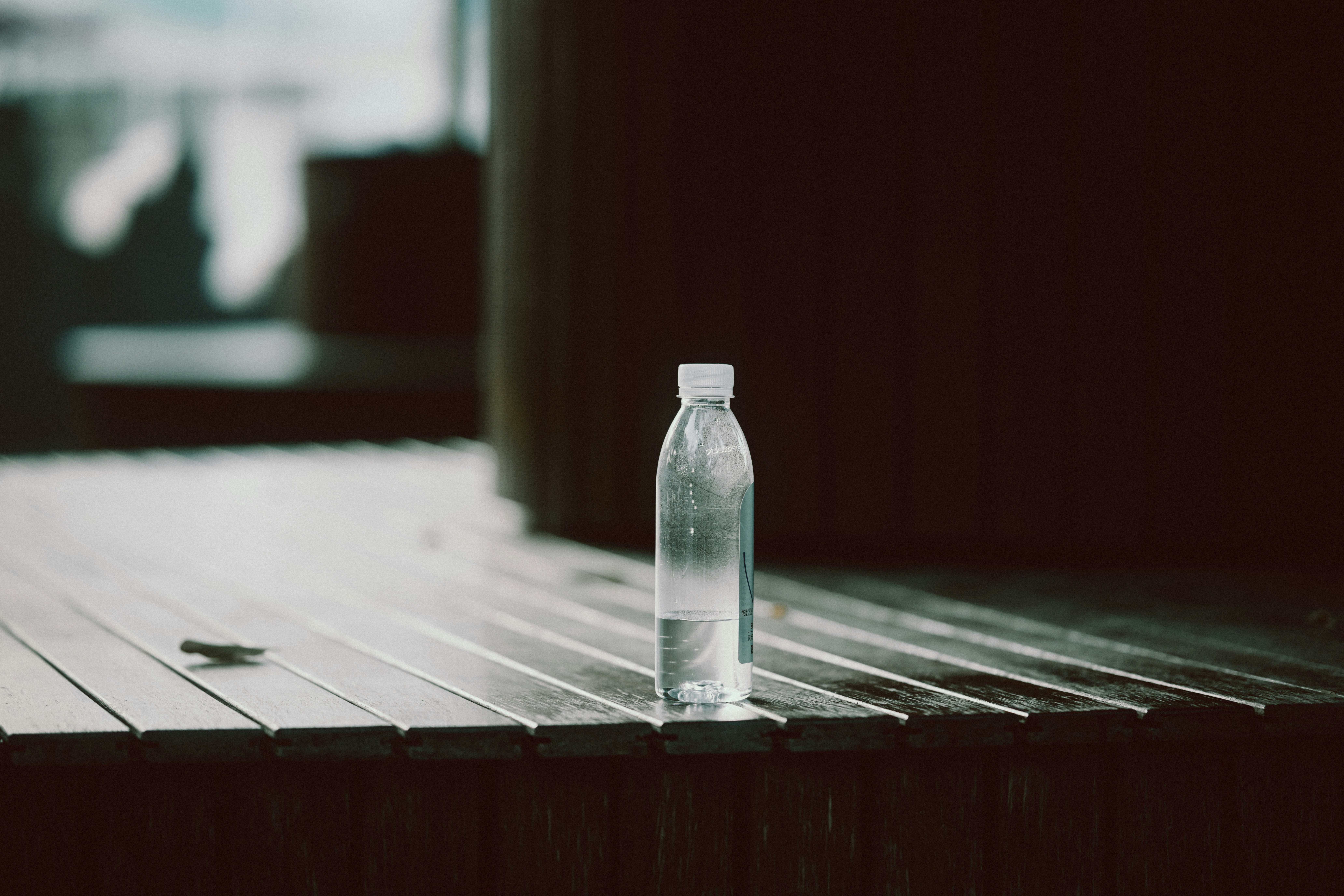 A Quiet Drop: The Bottle Centered on Weathered Wood