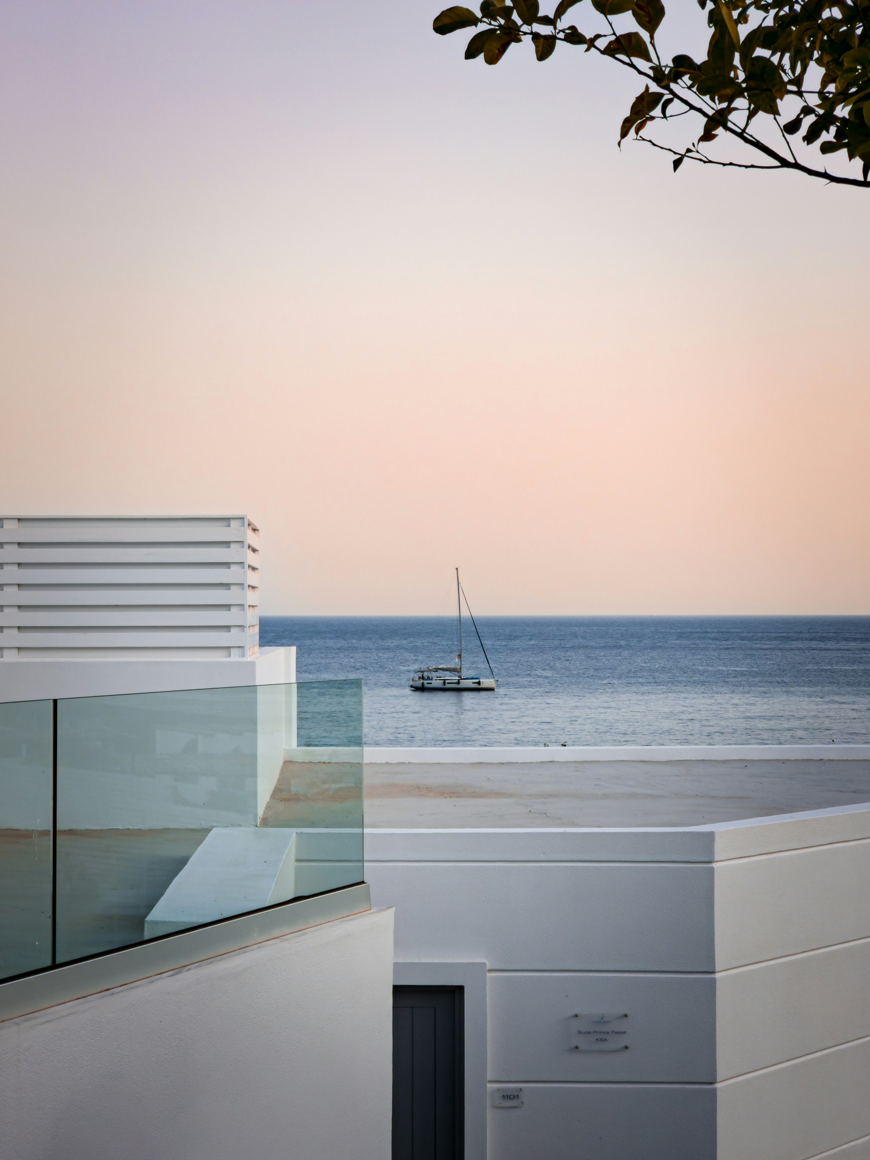 Sea Terrace at Dusk: Modern White Geometry Meets Quiet Sailboat