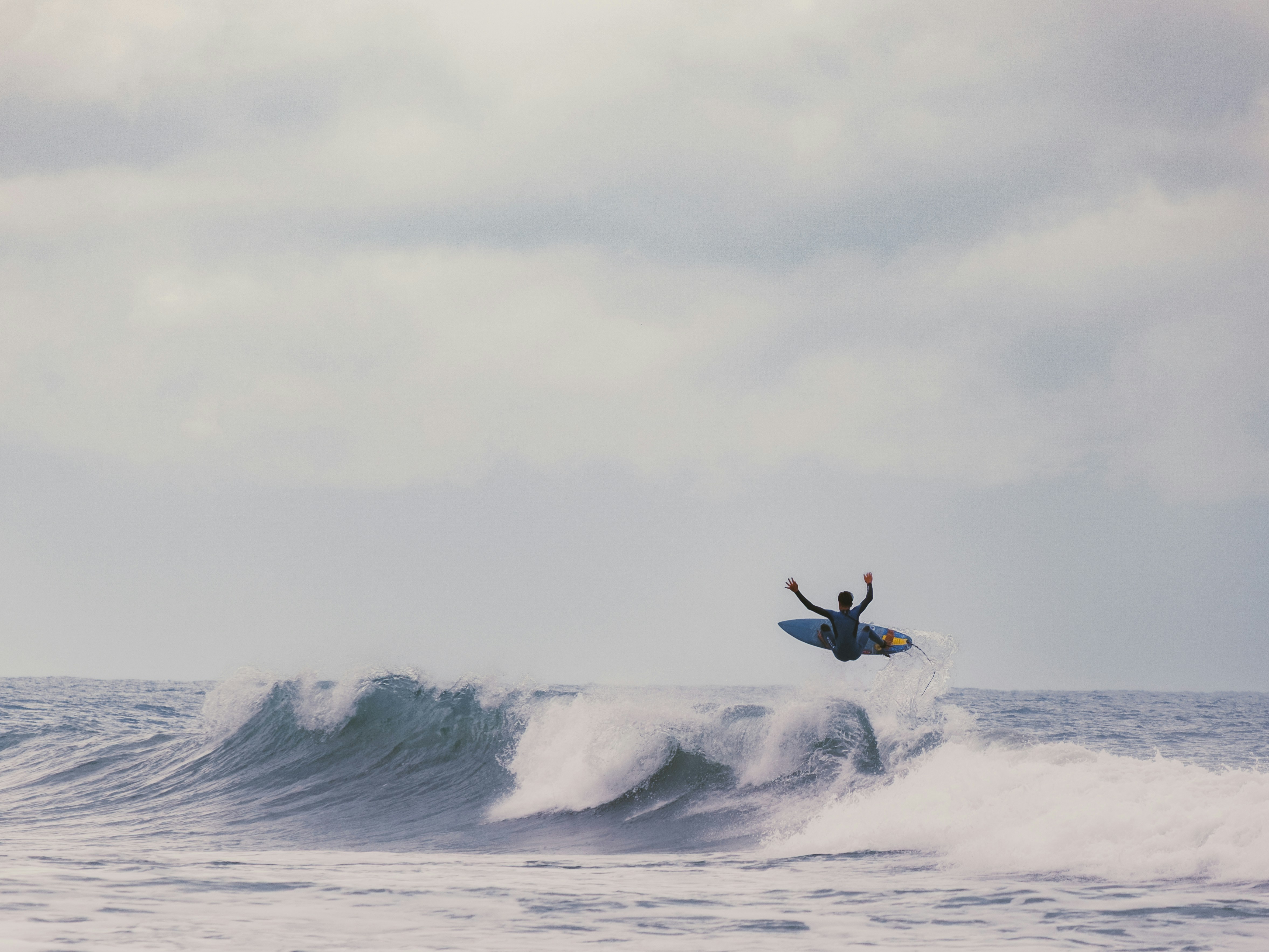 Surfing silhouette: rider carving a cresting wave at sea