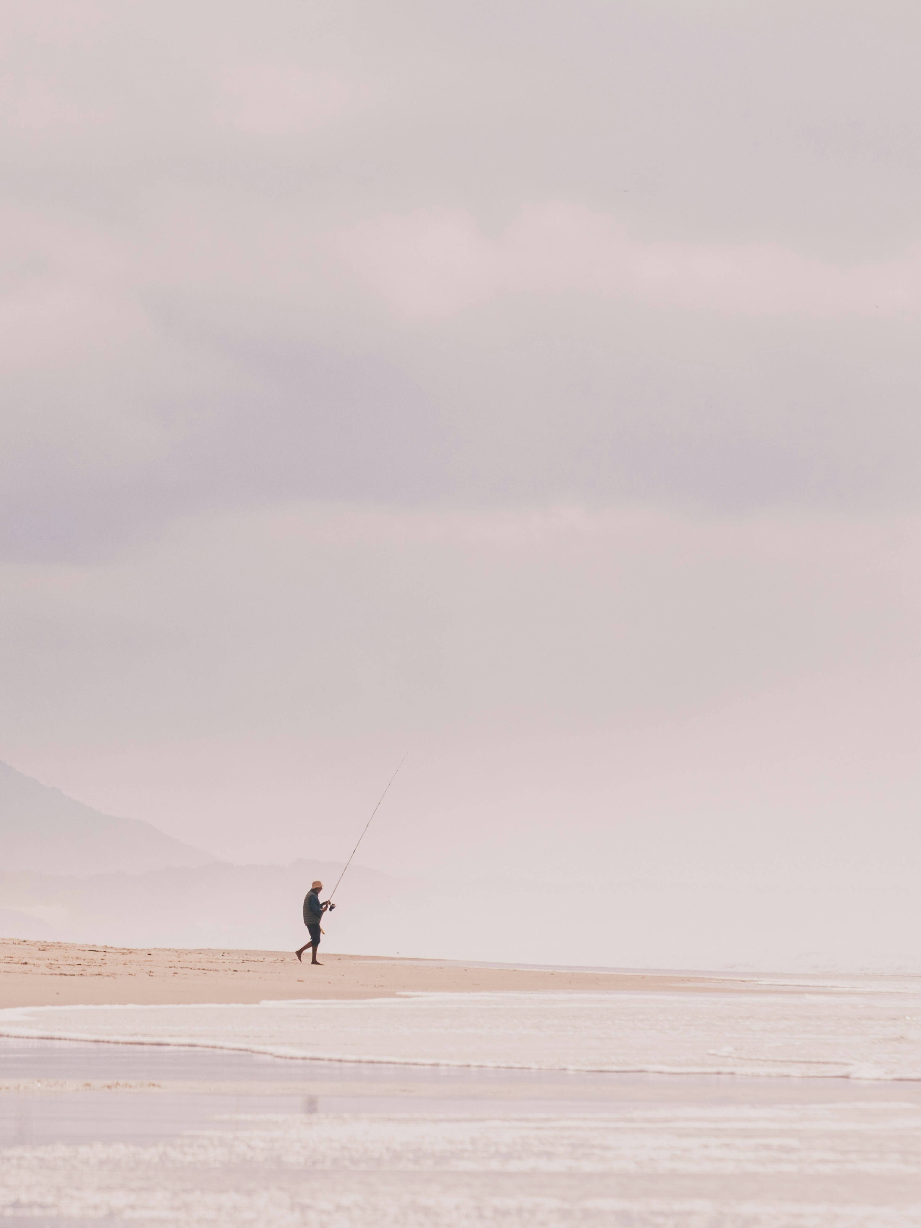 Single Angler on a Misty Shore: A Quiet Moment at the Edge of Light
