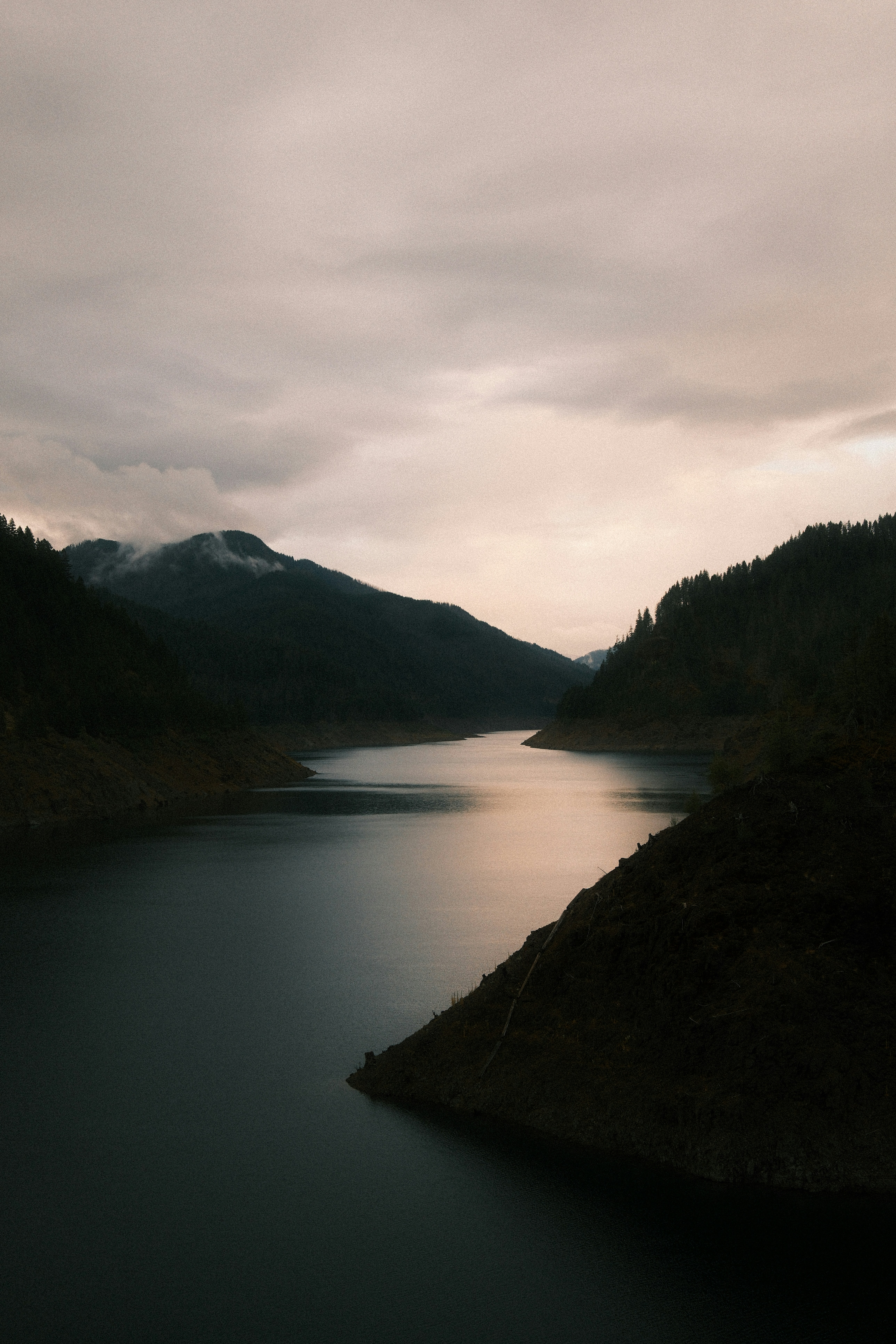 Dusk over a Serene Valley: A Quiet River Embraced by Majestic Peaks