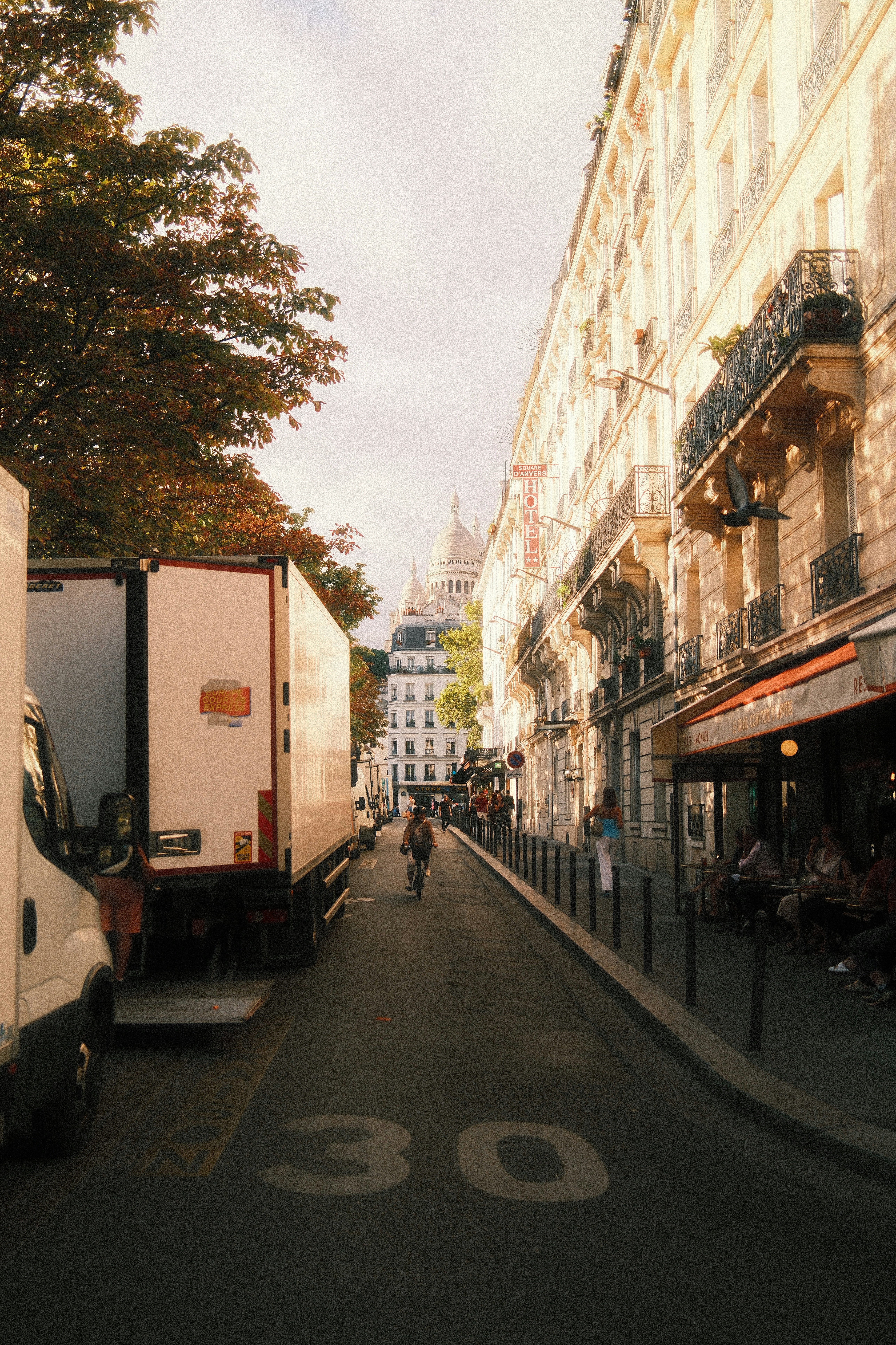 Parisian Street at Dusk: A Quiet Moment Beneath Balcony Ironwork