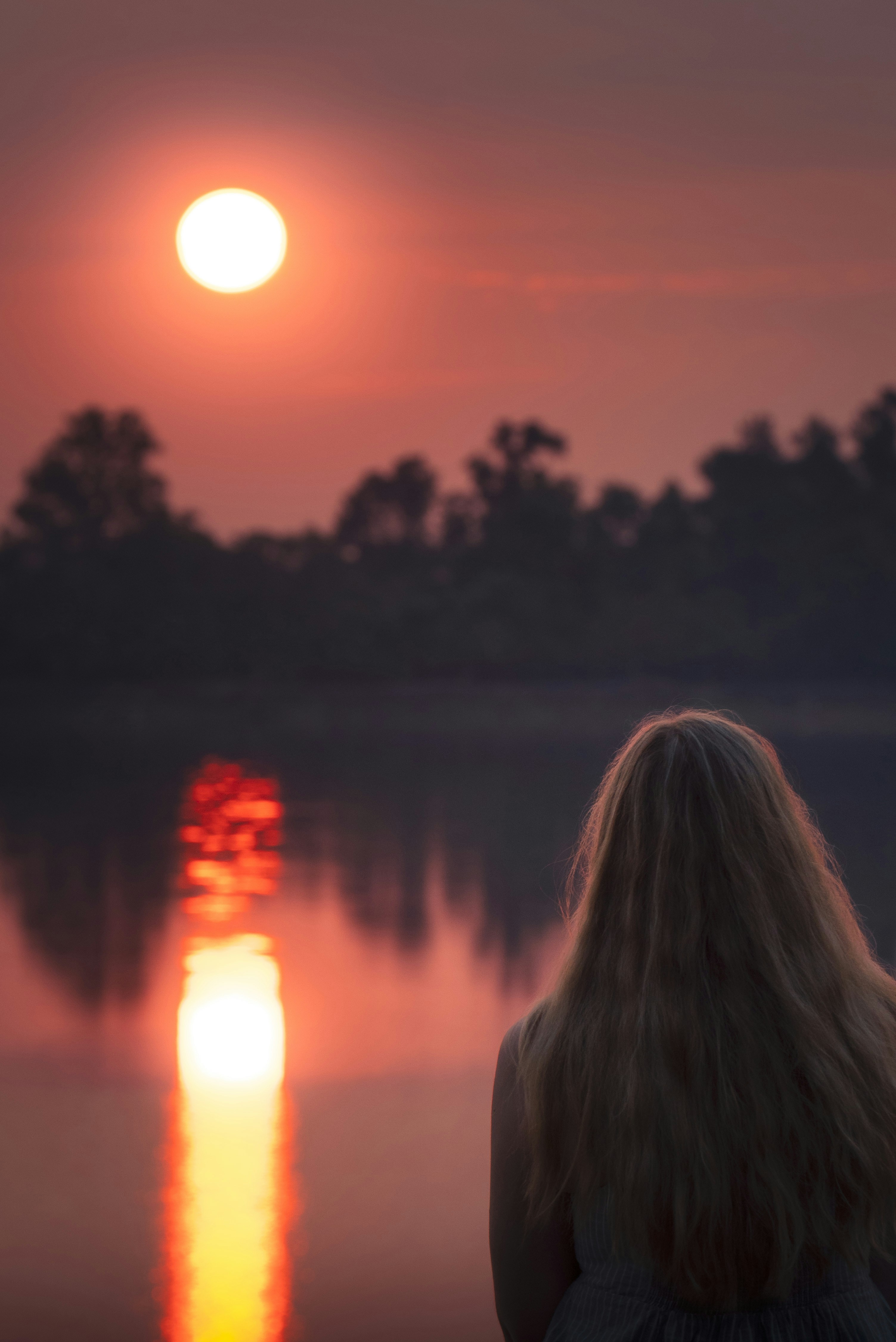 Sunset Silhouette: A Listener at the Water's Edge