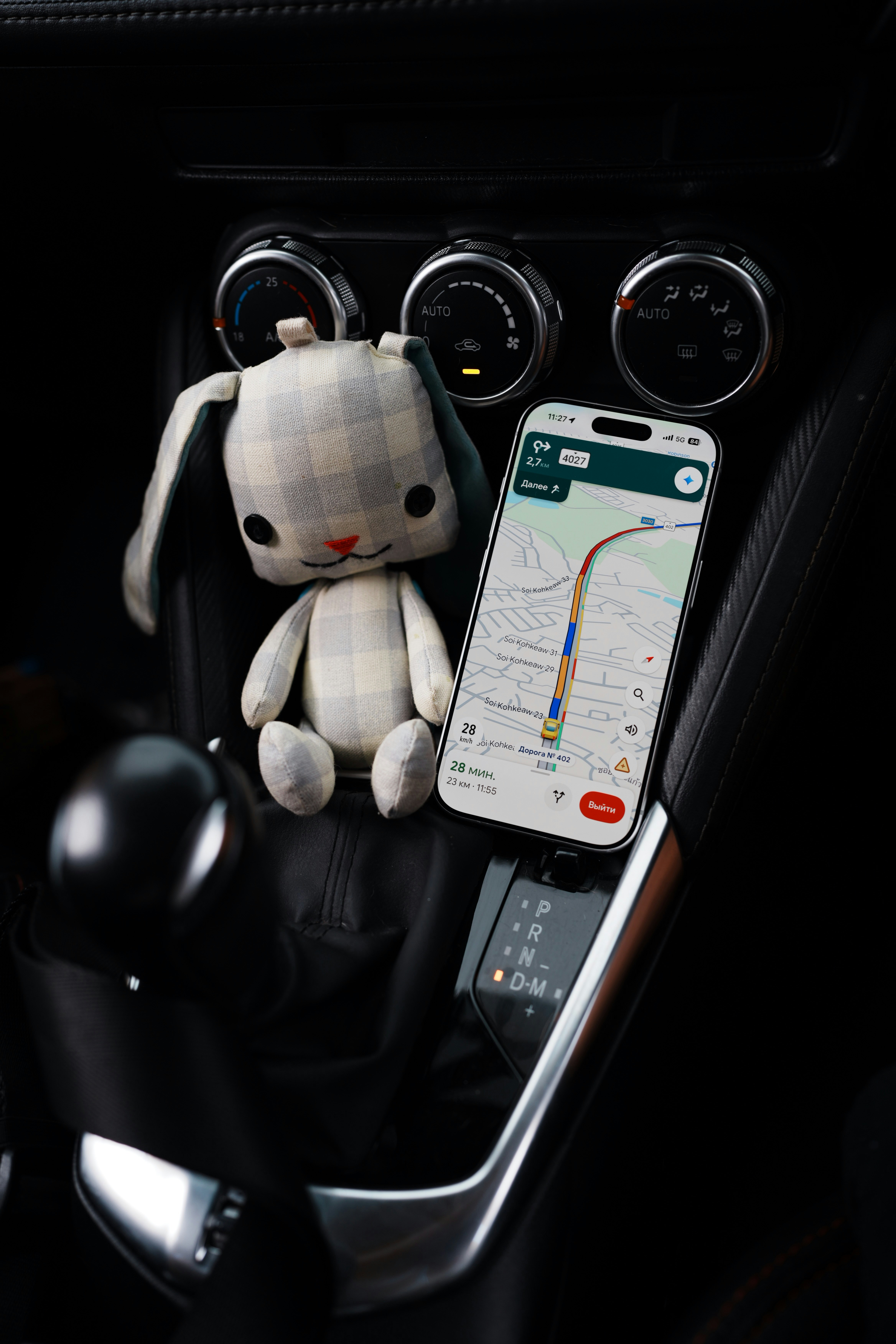 Toy bunny on a car console with a smartphone navigation map